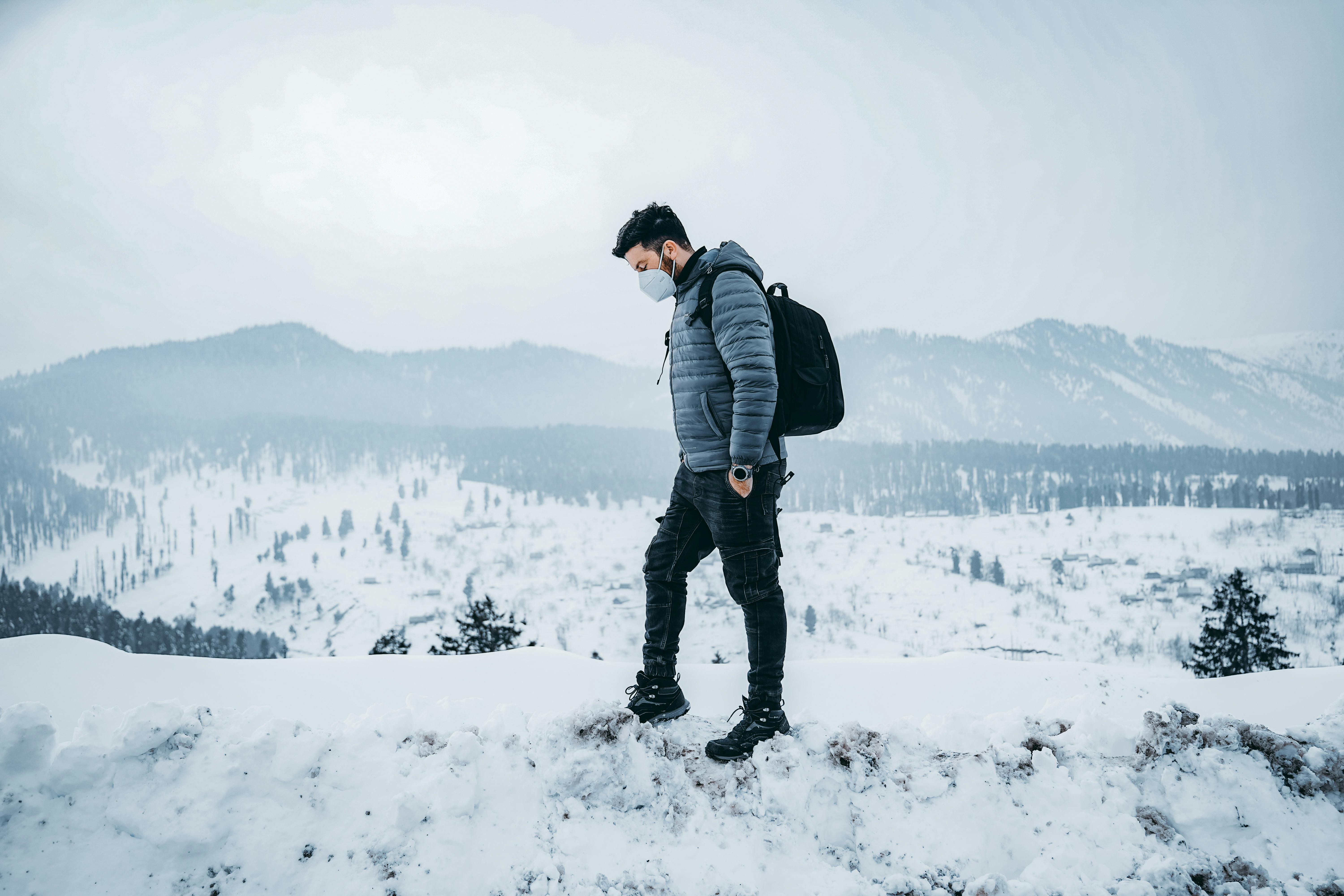 Adult man sitting by tree in forest and looking down · Free Stock Photo