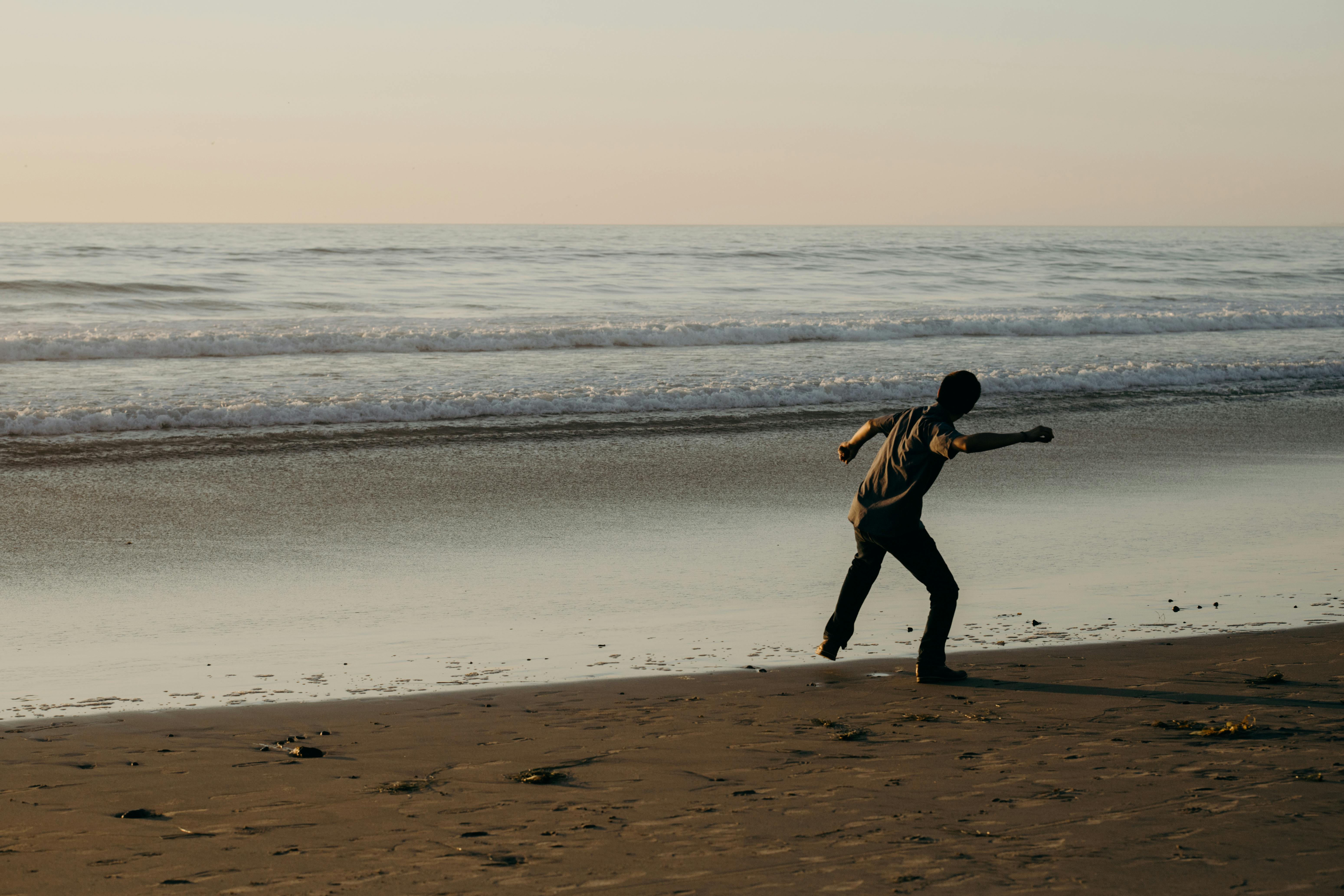 Person in a Slanted Position by the Shore · Free Stock Photo