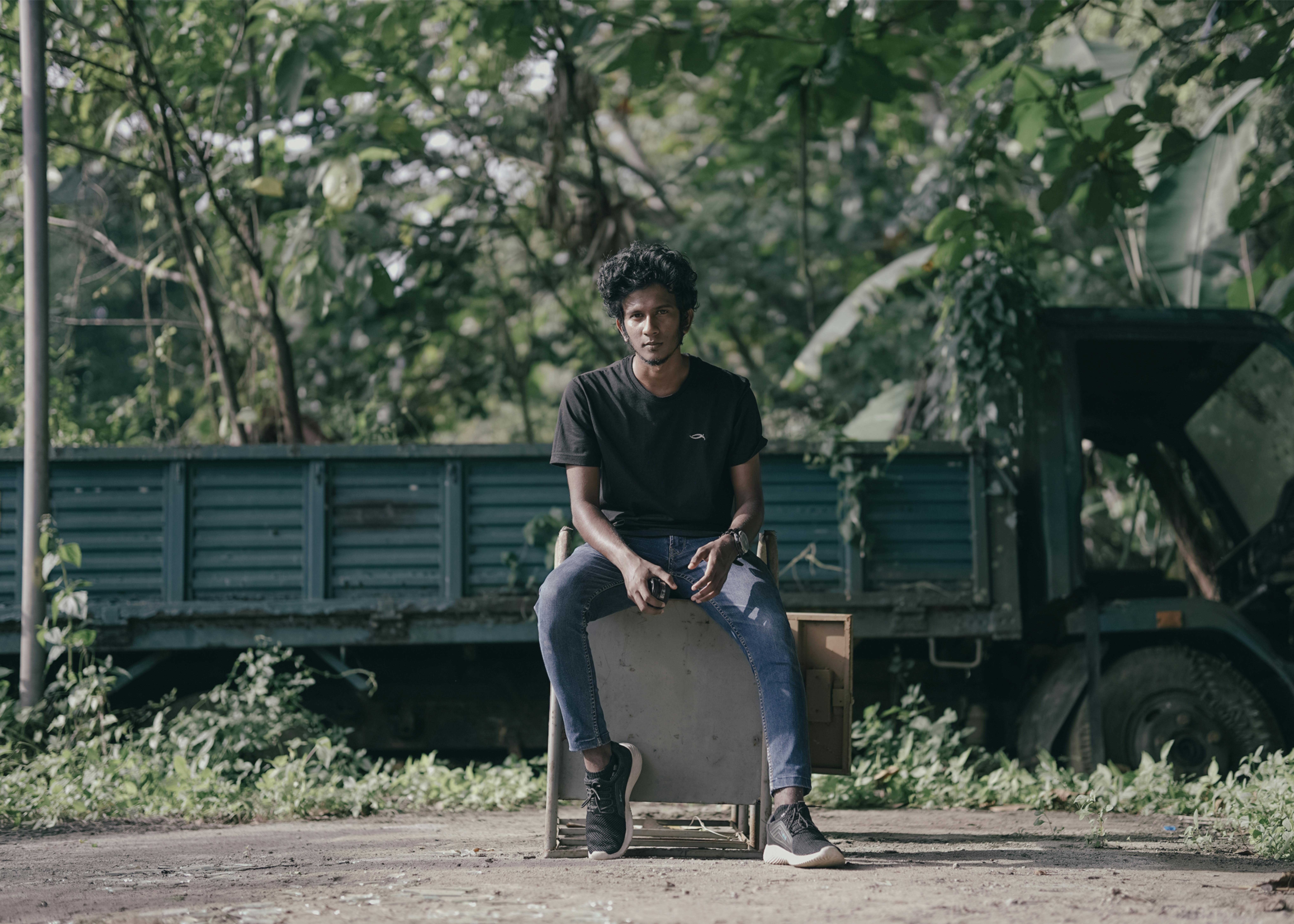Man Sitting on Box in front of Truck · Free Stock Photo