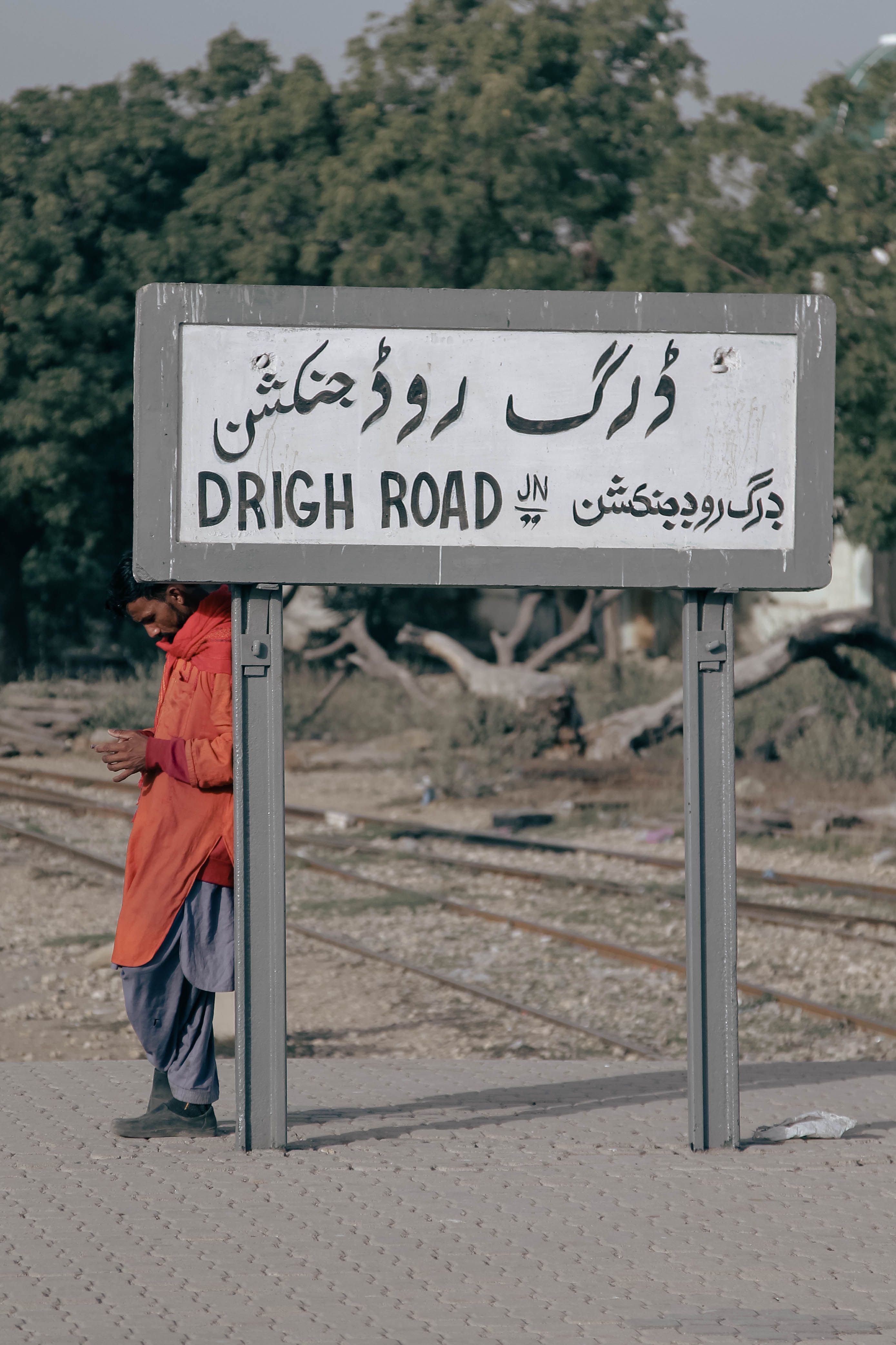 A Man Standing Beside the Road Sign · Free Stock Photo
