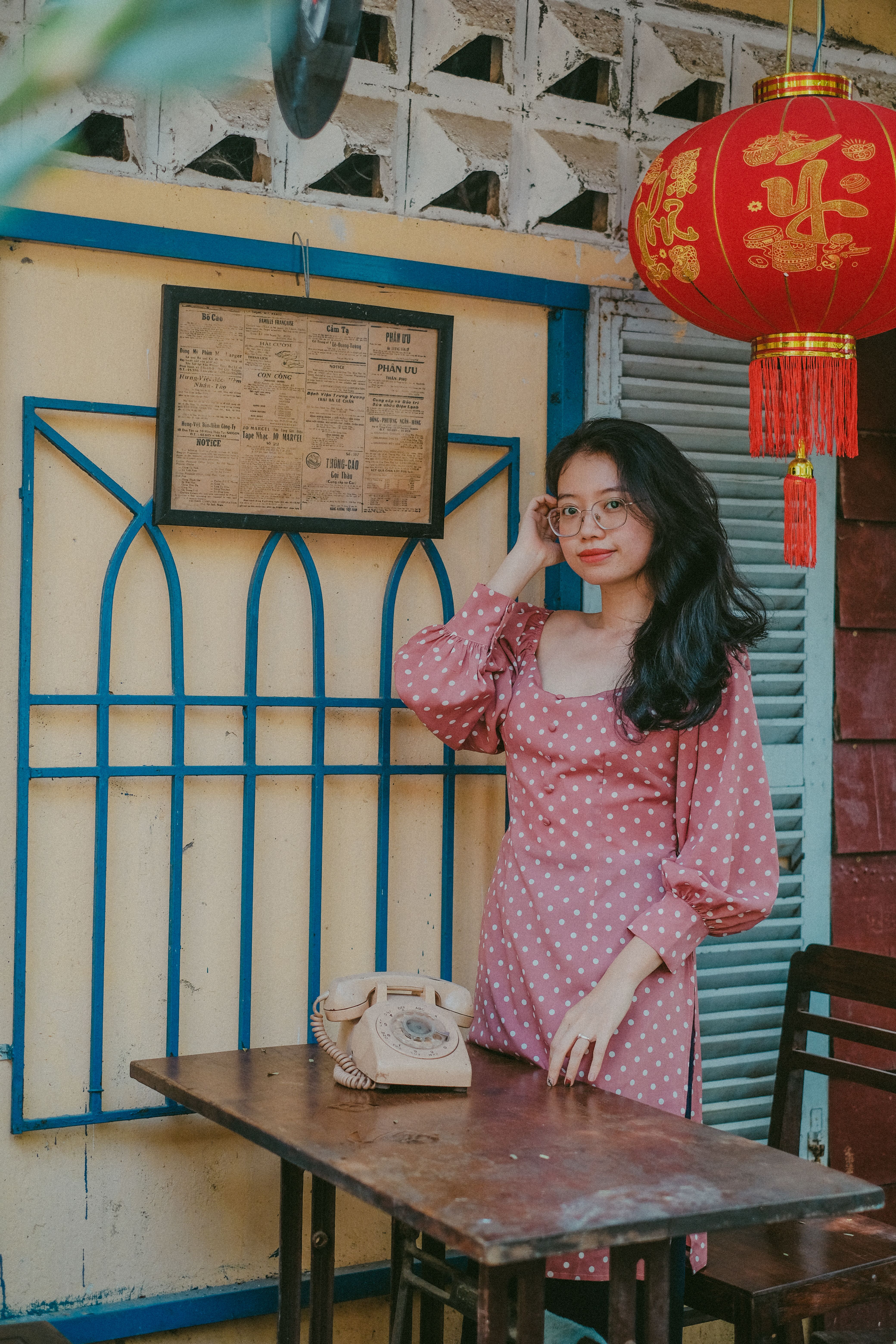 Woman Standing by Table with Classic Telephone · Free Stock Photo
