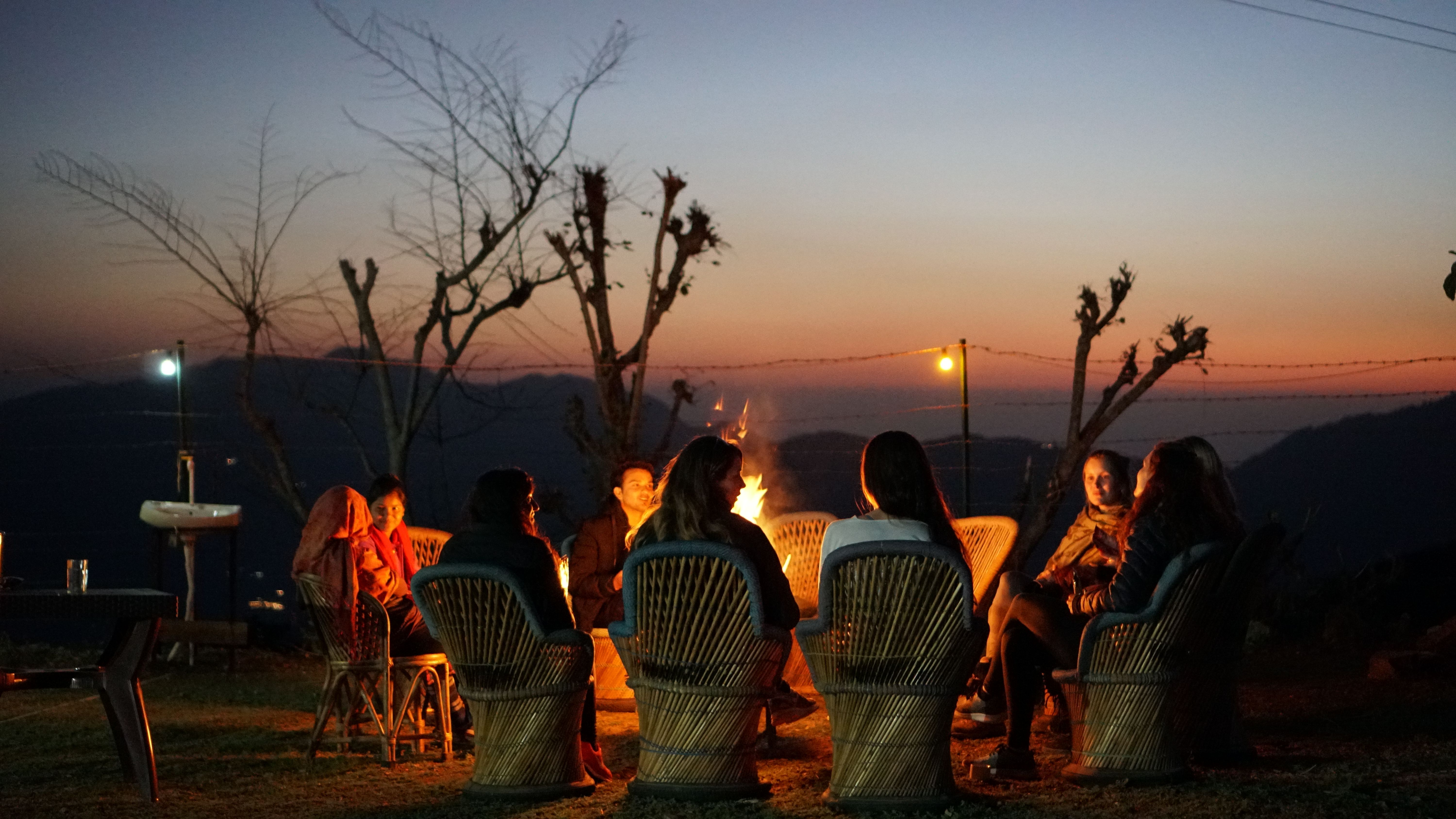People Sitting Around a Bonfire at Sunset · Free Stock Photo