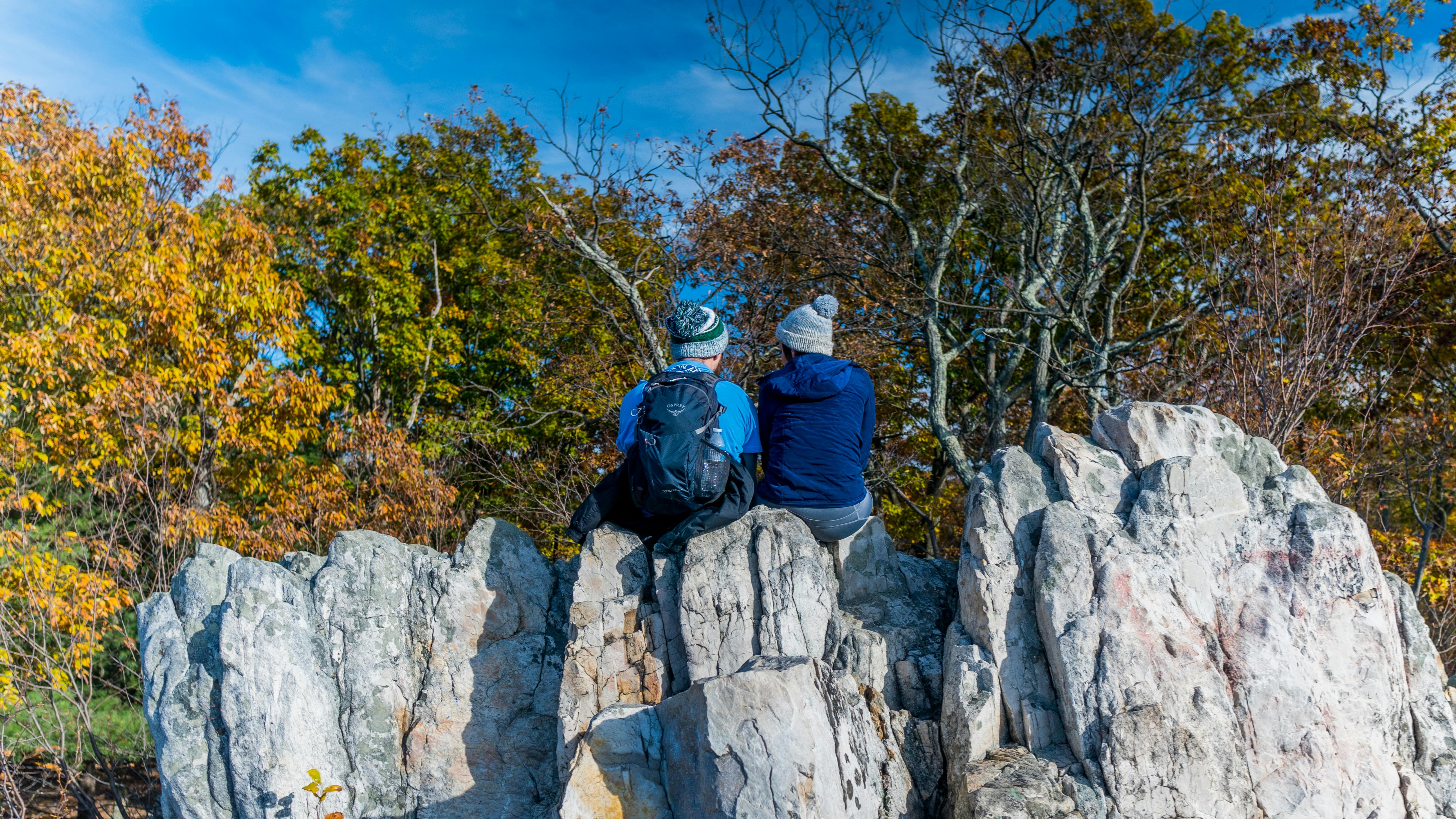 Back View of Two People Sitting on the Big Rock · Free Stock Photo