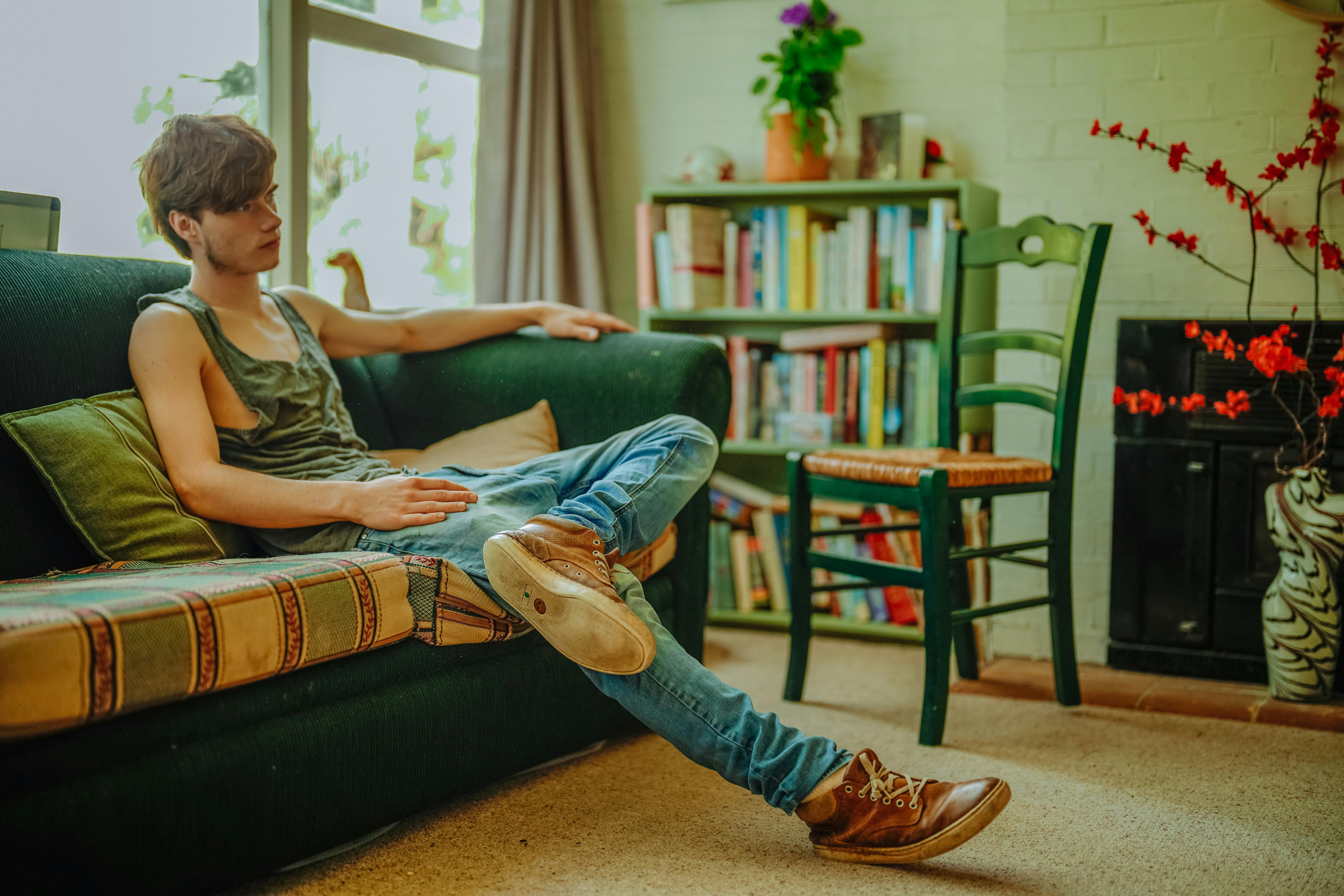 A Young Man Sitting Comfortably on the Sofa · Free Stock Photo