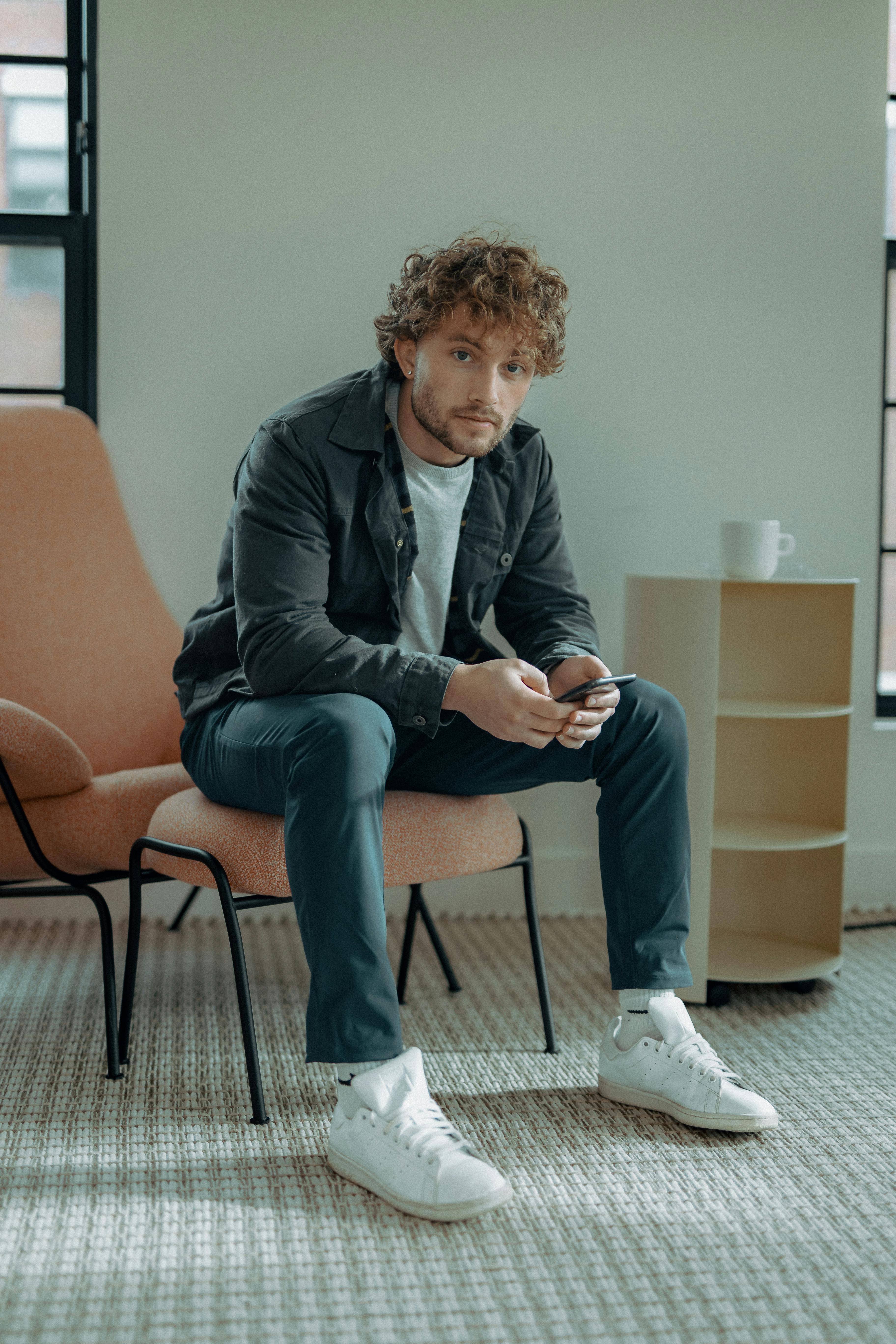 A Man Sitting with a Smart Phone · Free Stock Photo