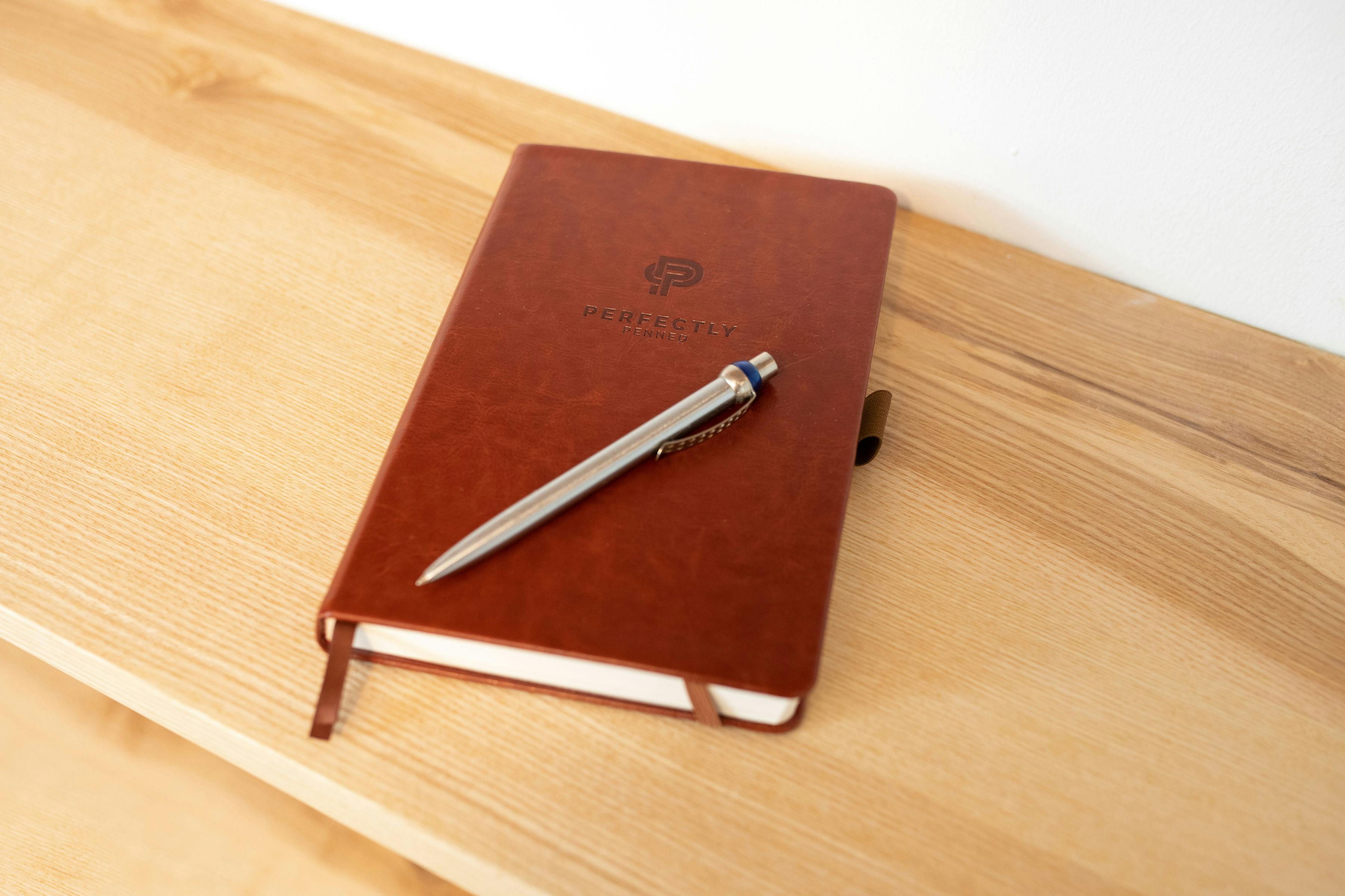 Notebook opened on desk near books · Free Stock Photo