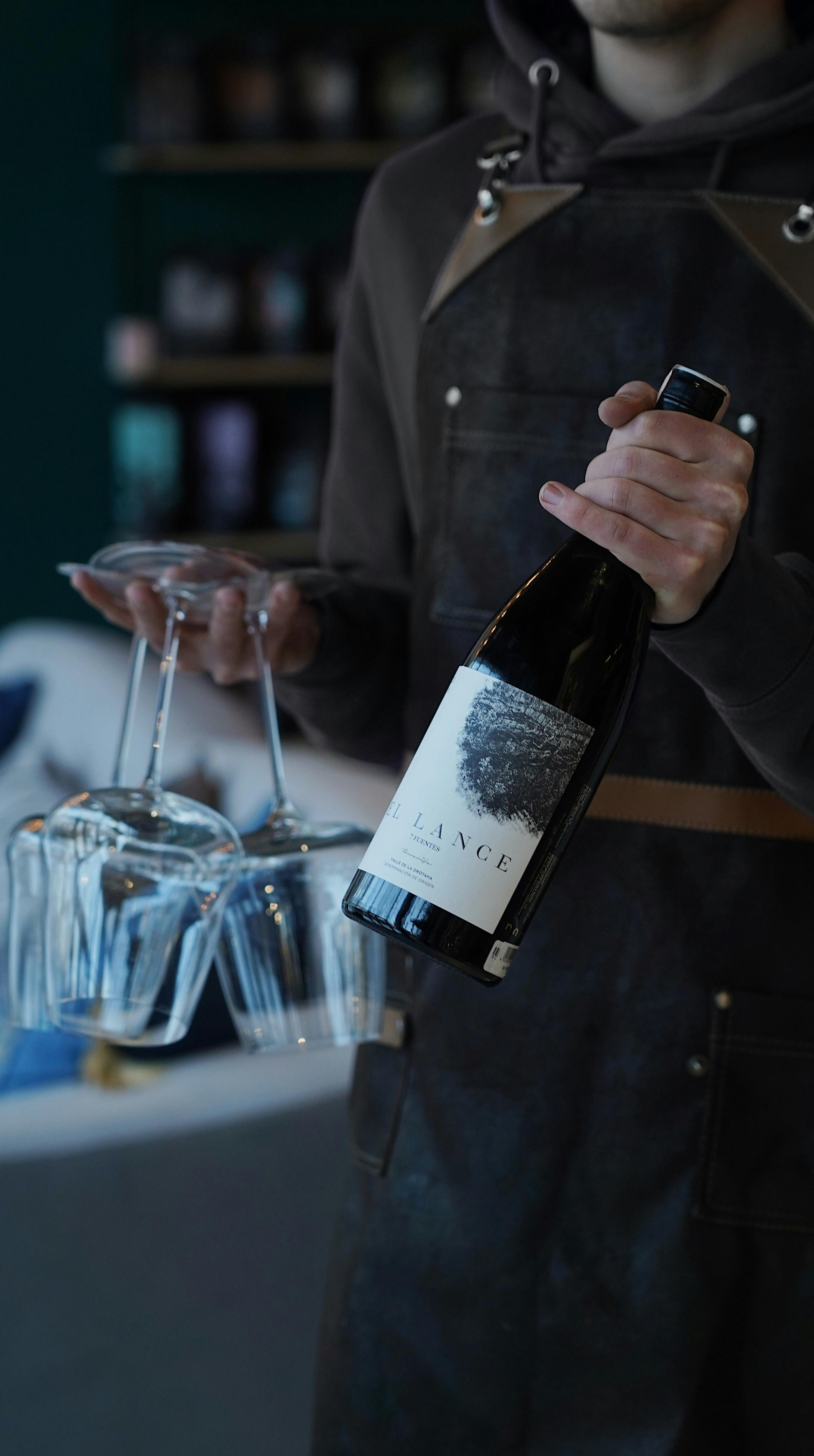 Man Holding Wine Bottle While Jumping from Wooden Dock · Free Stock Photo