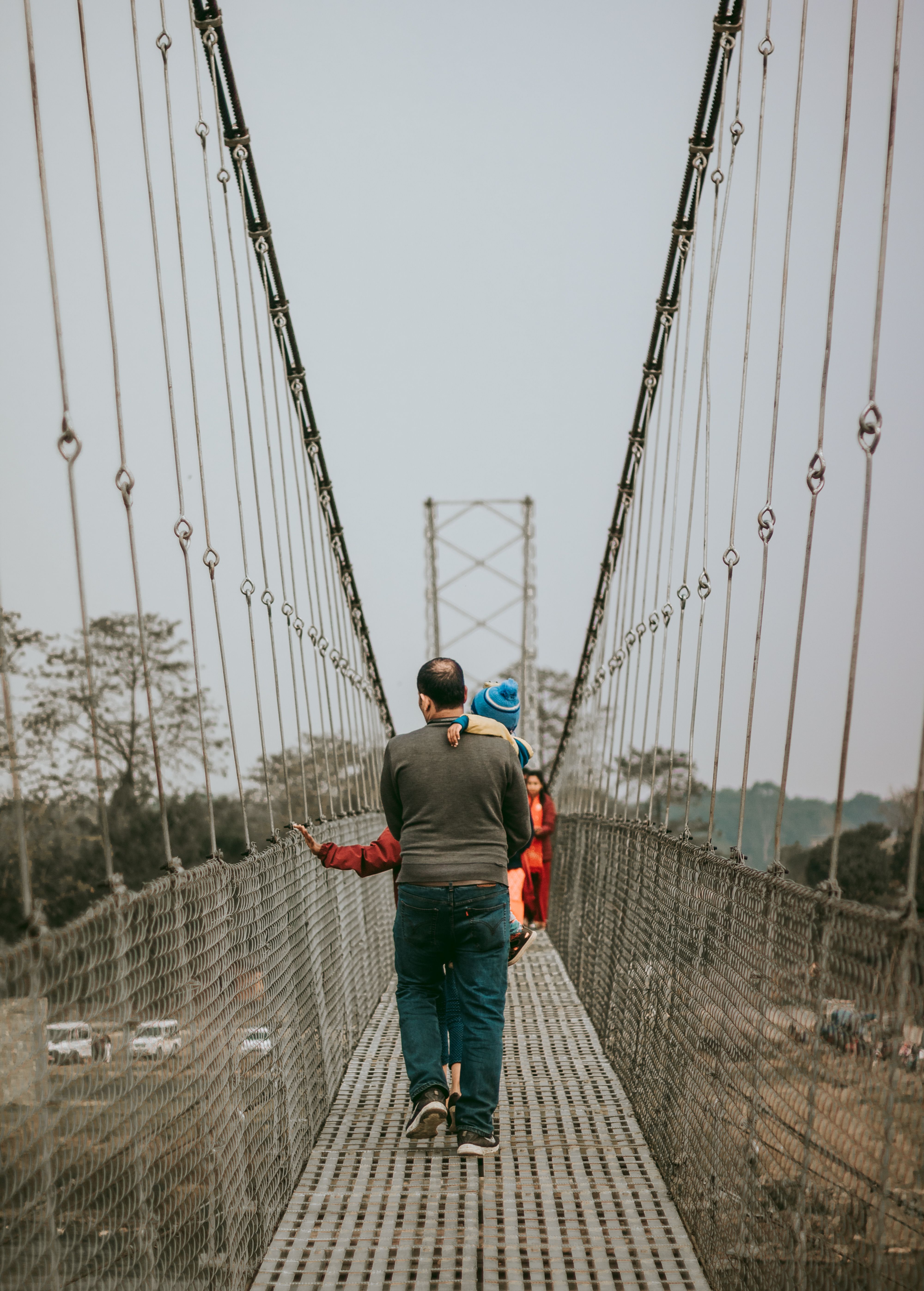 Man in Green Jacket and Black Pants Walking on Hanging Bridge · Free ...