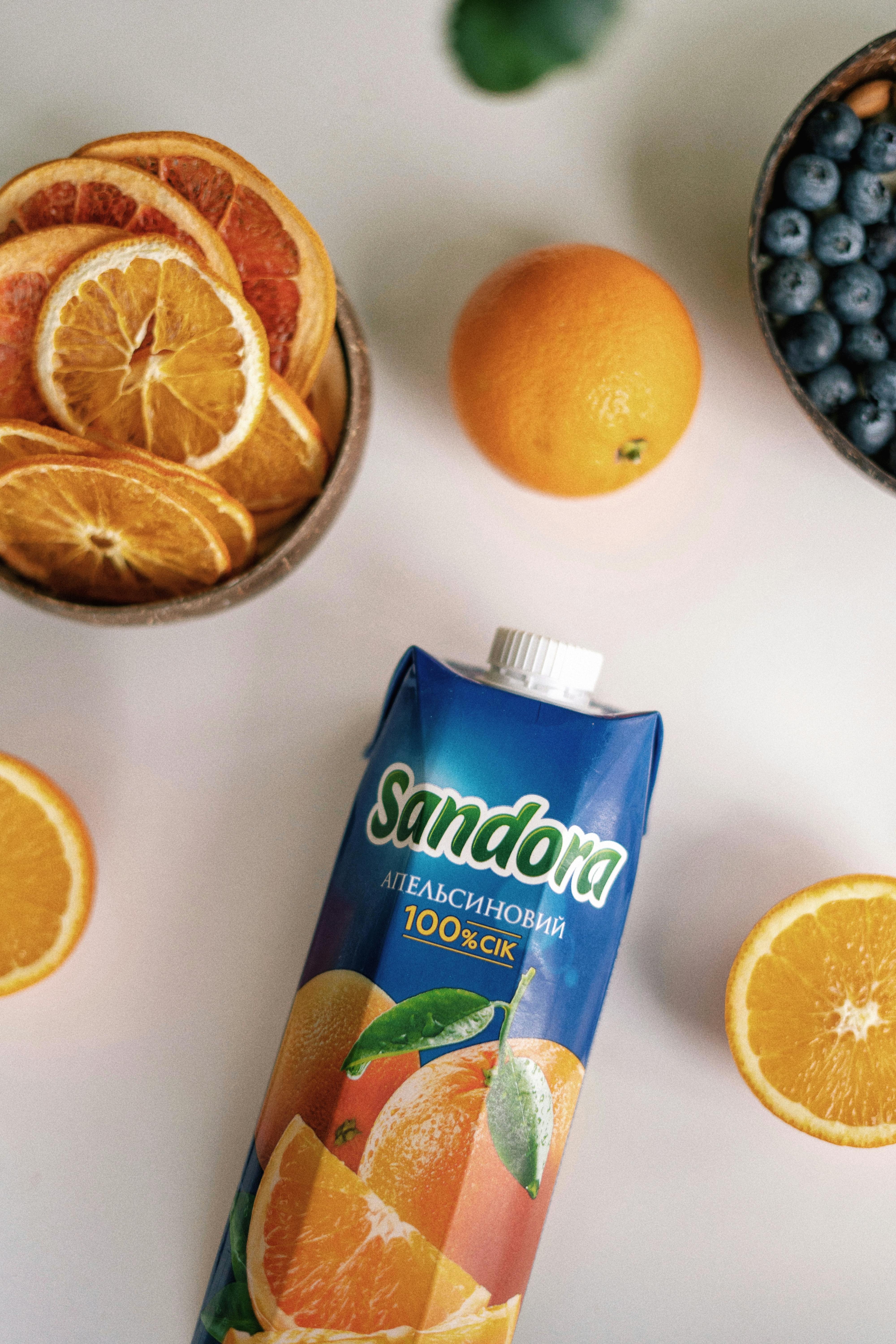 A Sandora Juice Drink in Tetra Pak Near a Bowl of Mandarin Slices ...