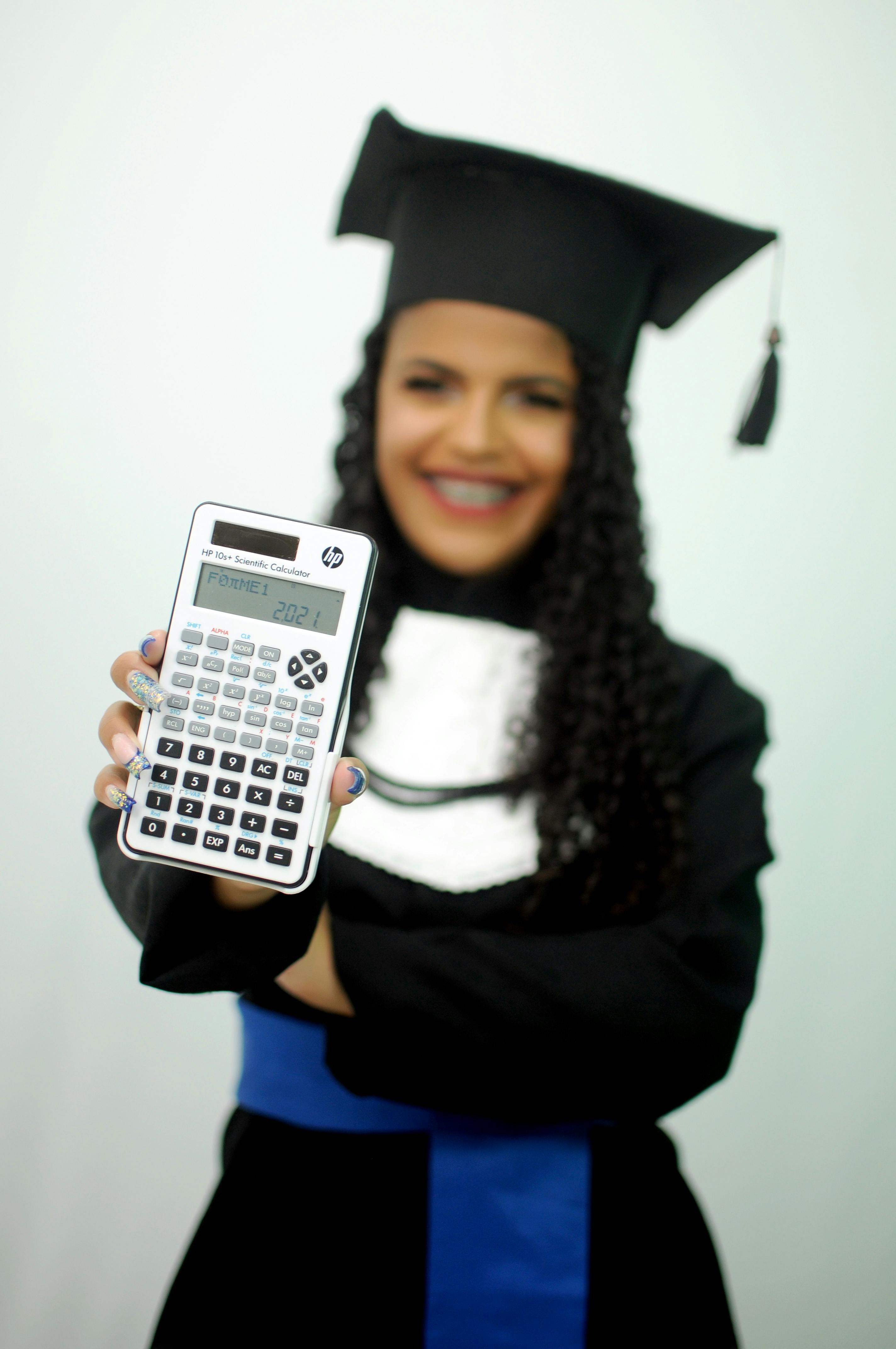 Graduate Holding a Calculator · Free Stock Photo