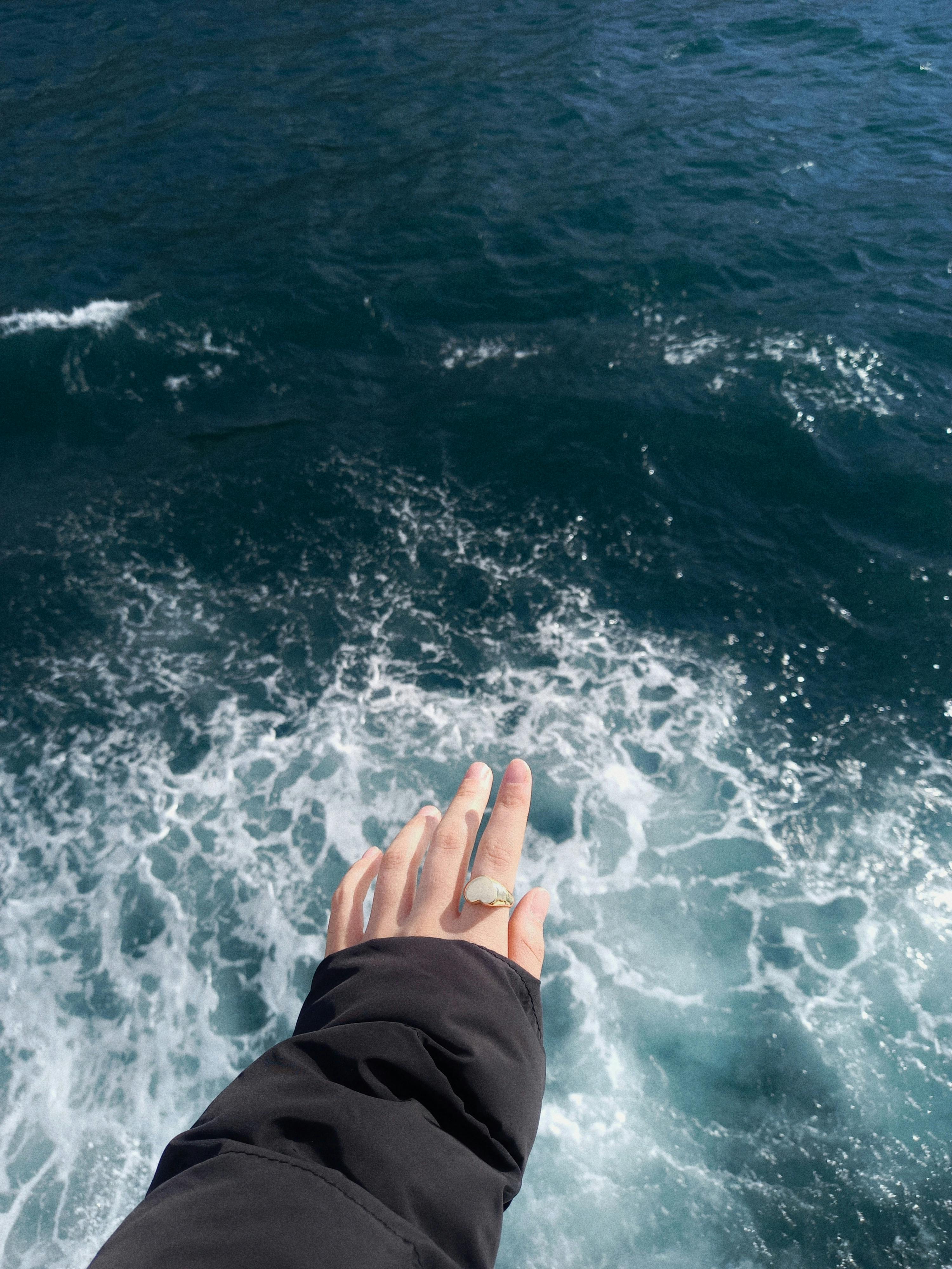 Hand against Sea Water · Free Stock Photo