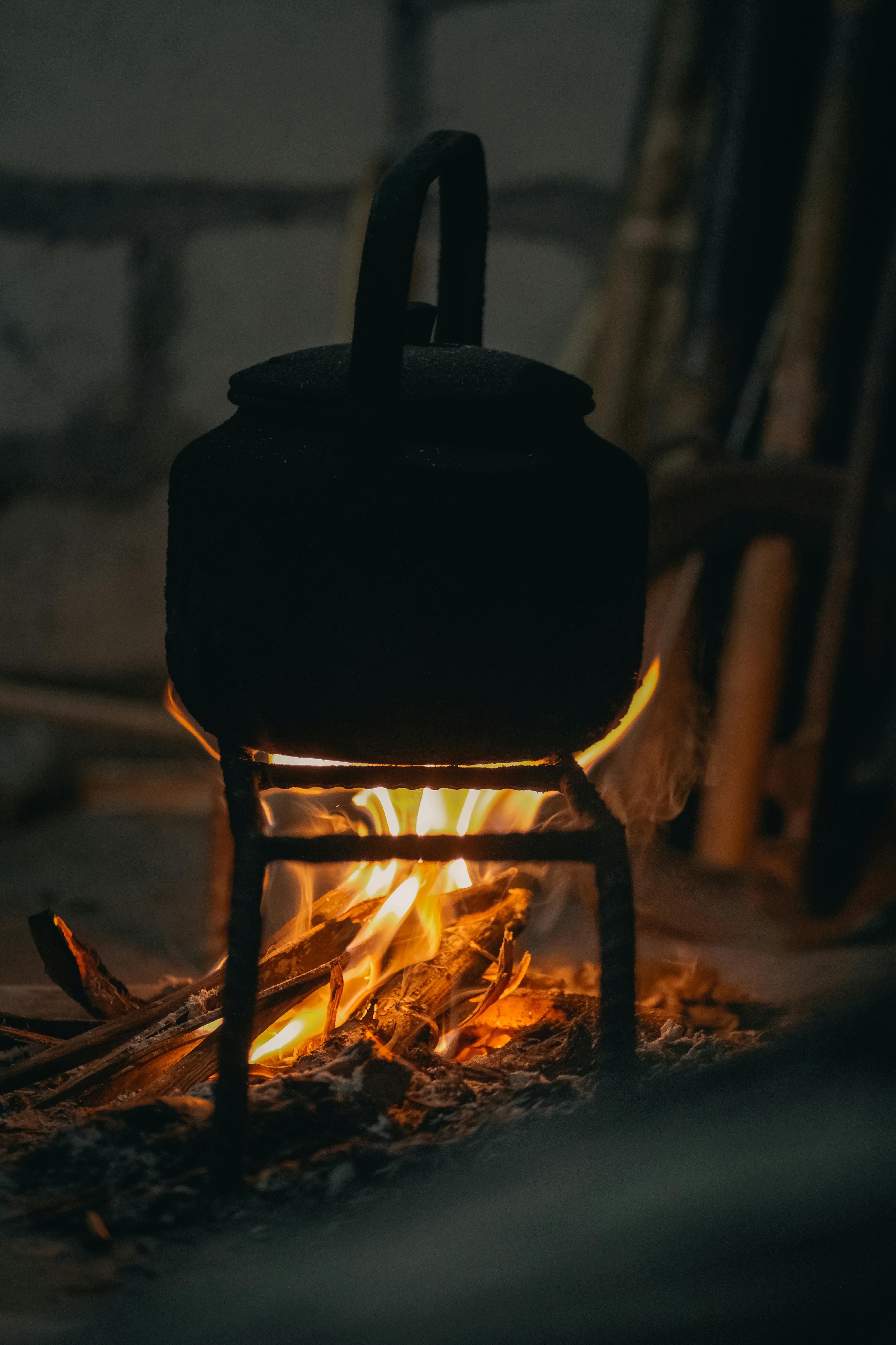 Hand in Glove Holding Kettle over Bonfire in Winter · Free Stock Photo