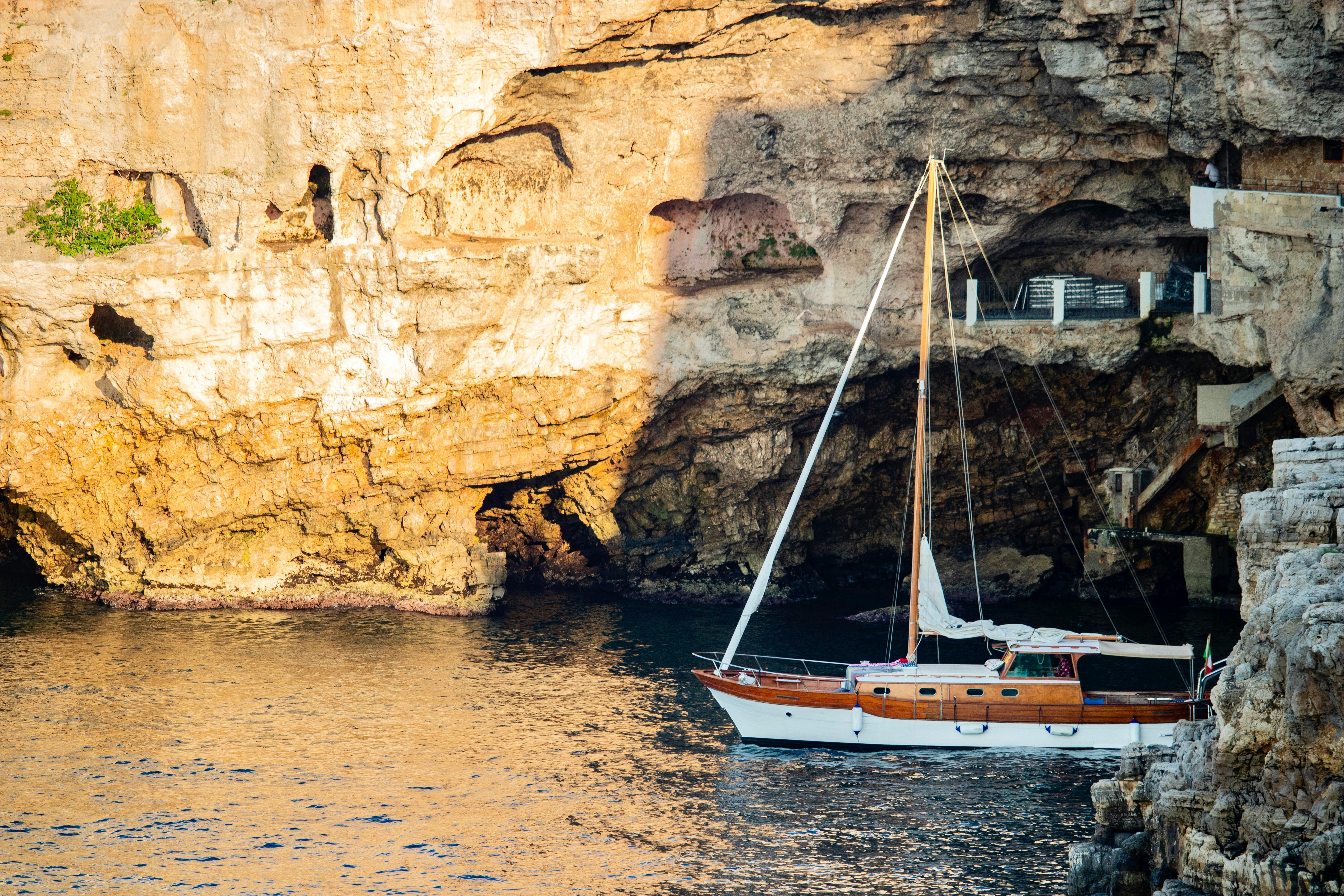 Sailboat in the Sea Next to a Cliff · Free Stock Photo
