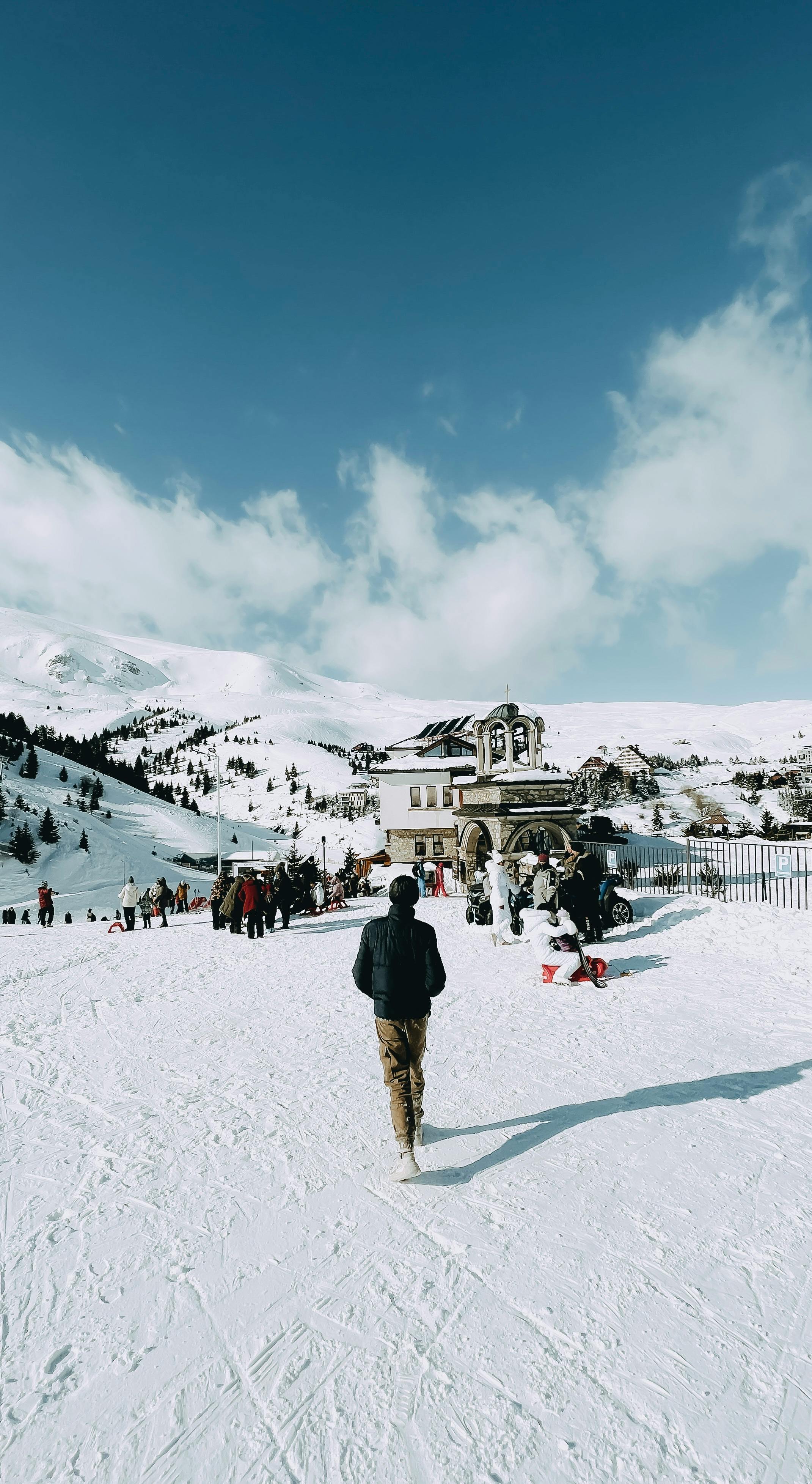 A Woman Walking on Snow Covered Pathway · Free Stock Photo