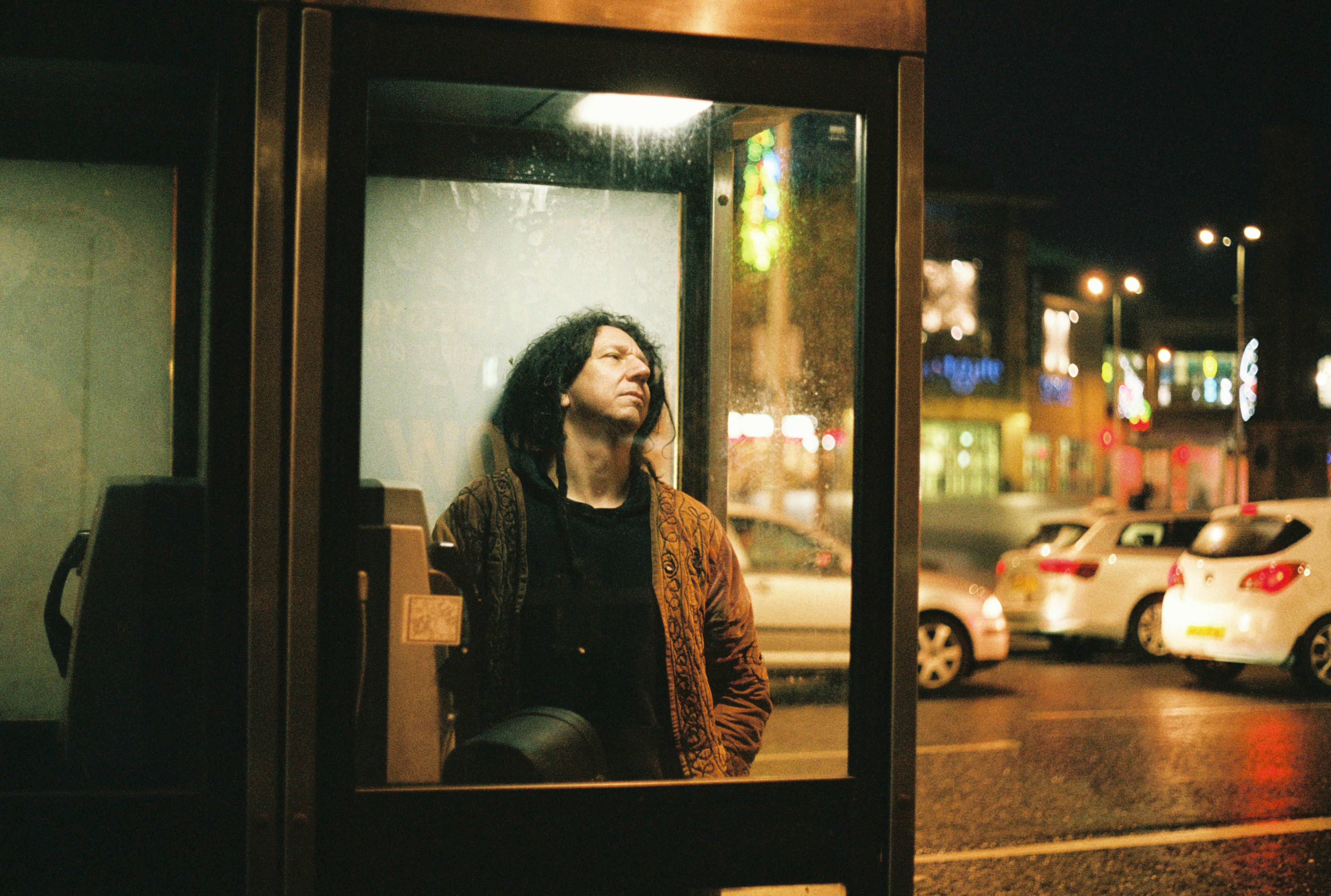 Man Inside the Telephone Booth near the Road · Free Stock Photo