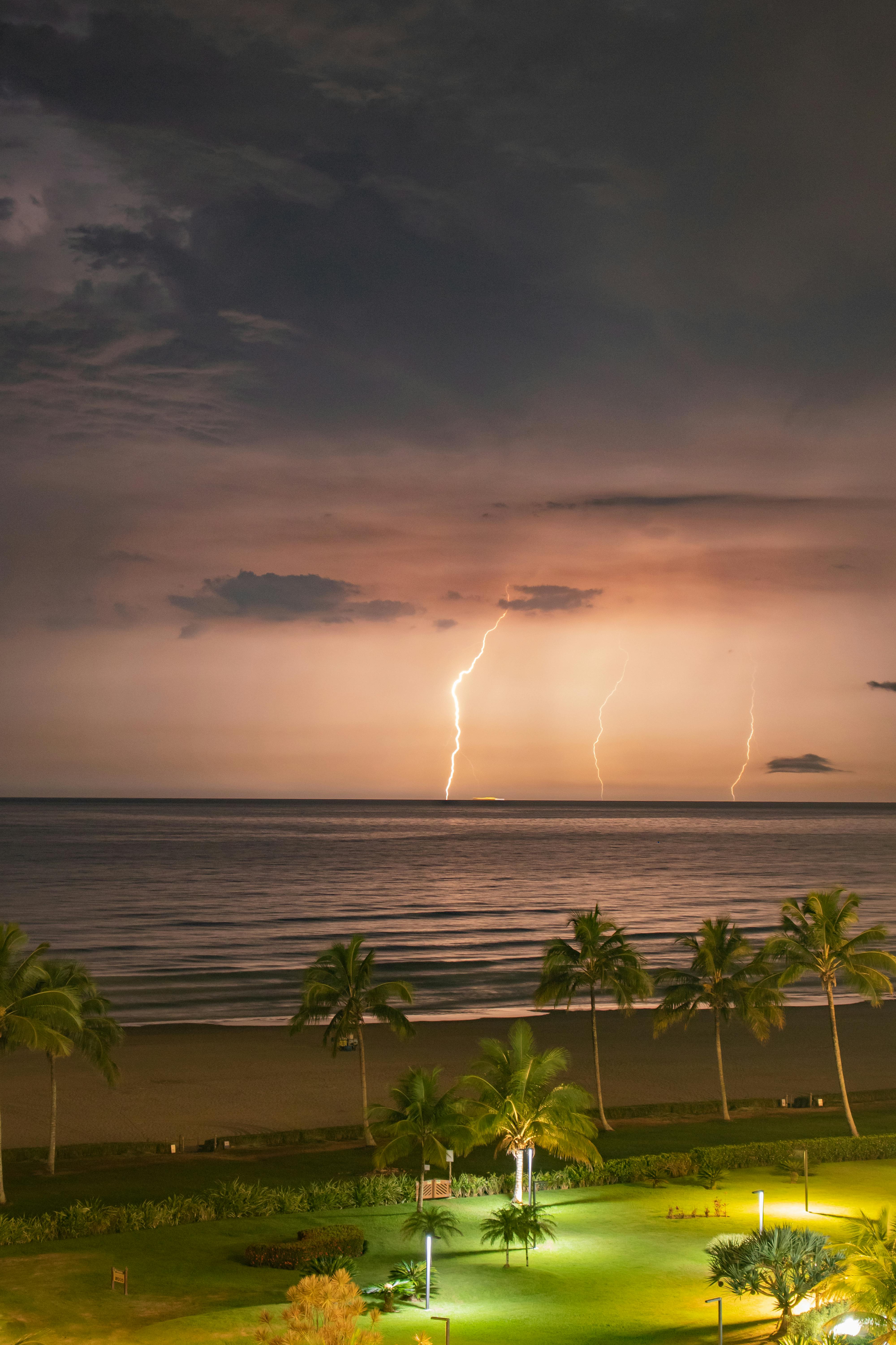 A View of Lightning Strikes at the Ocean from a Beach · Free Stock Photo