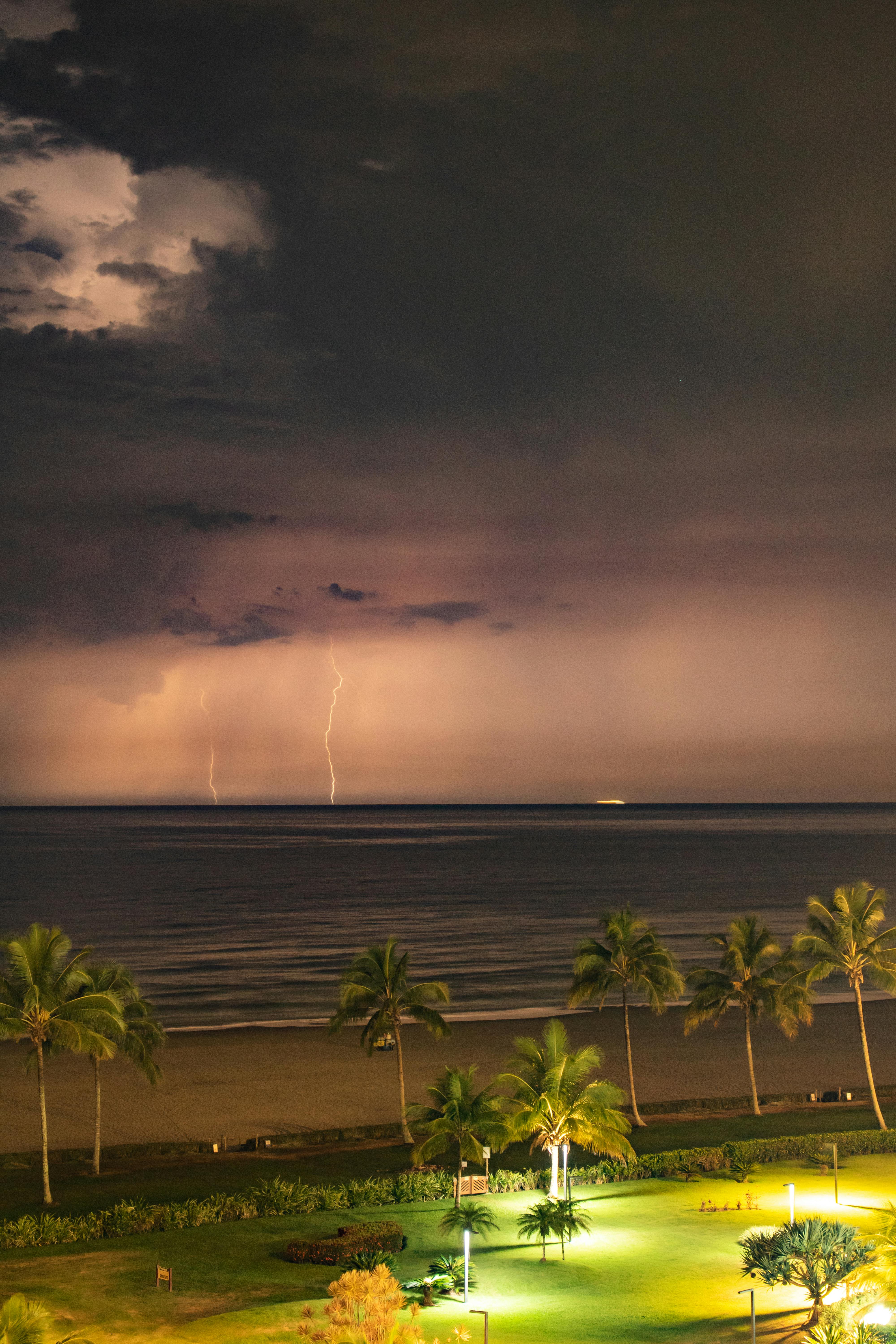 A View of Lightning Strikes at the Ocean from a Beach · Free Stock Photo