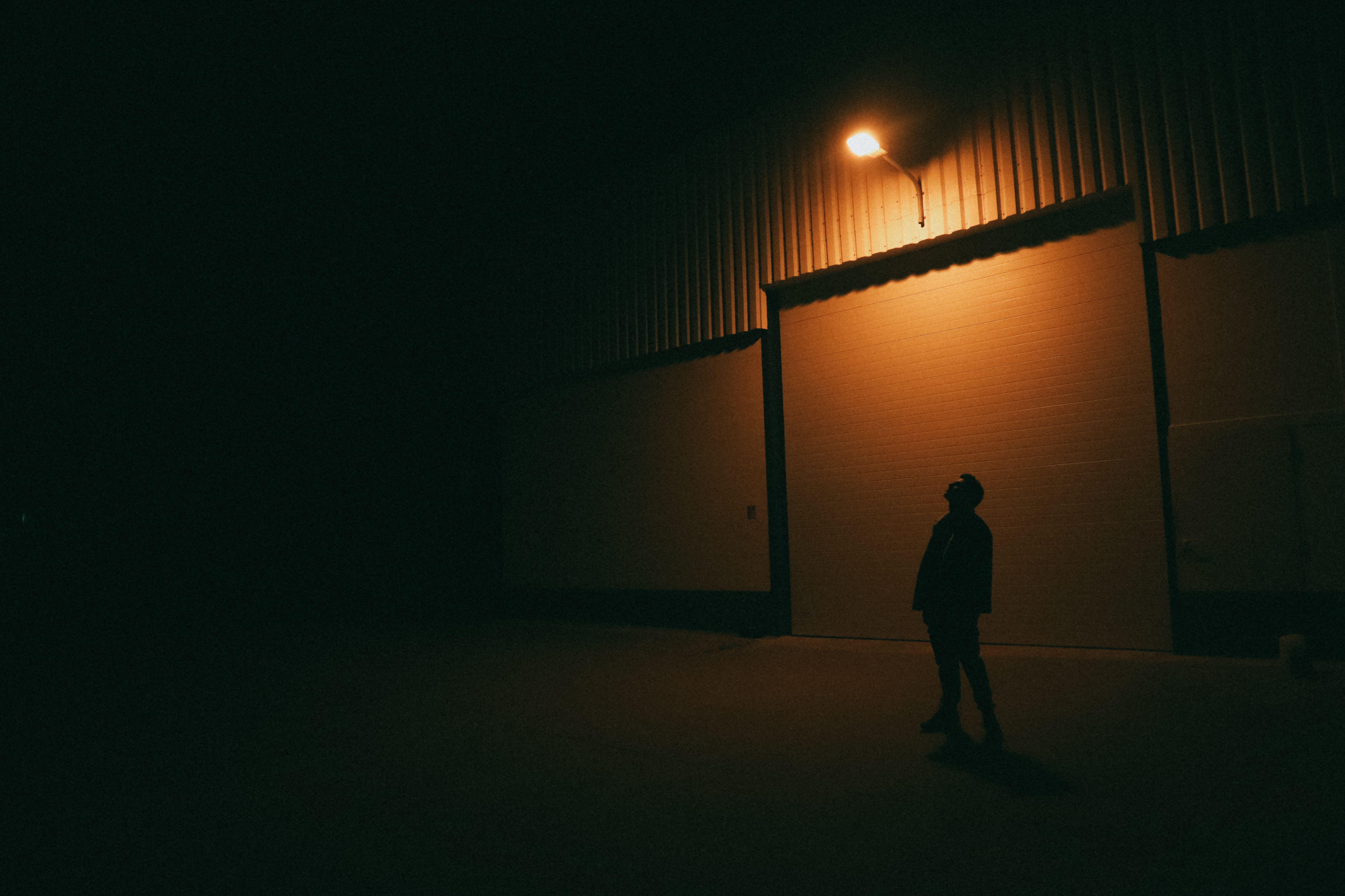 Lonely Figure Under Night Sky with Phone Glow · Free Stock Photo