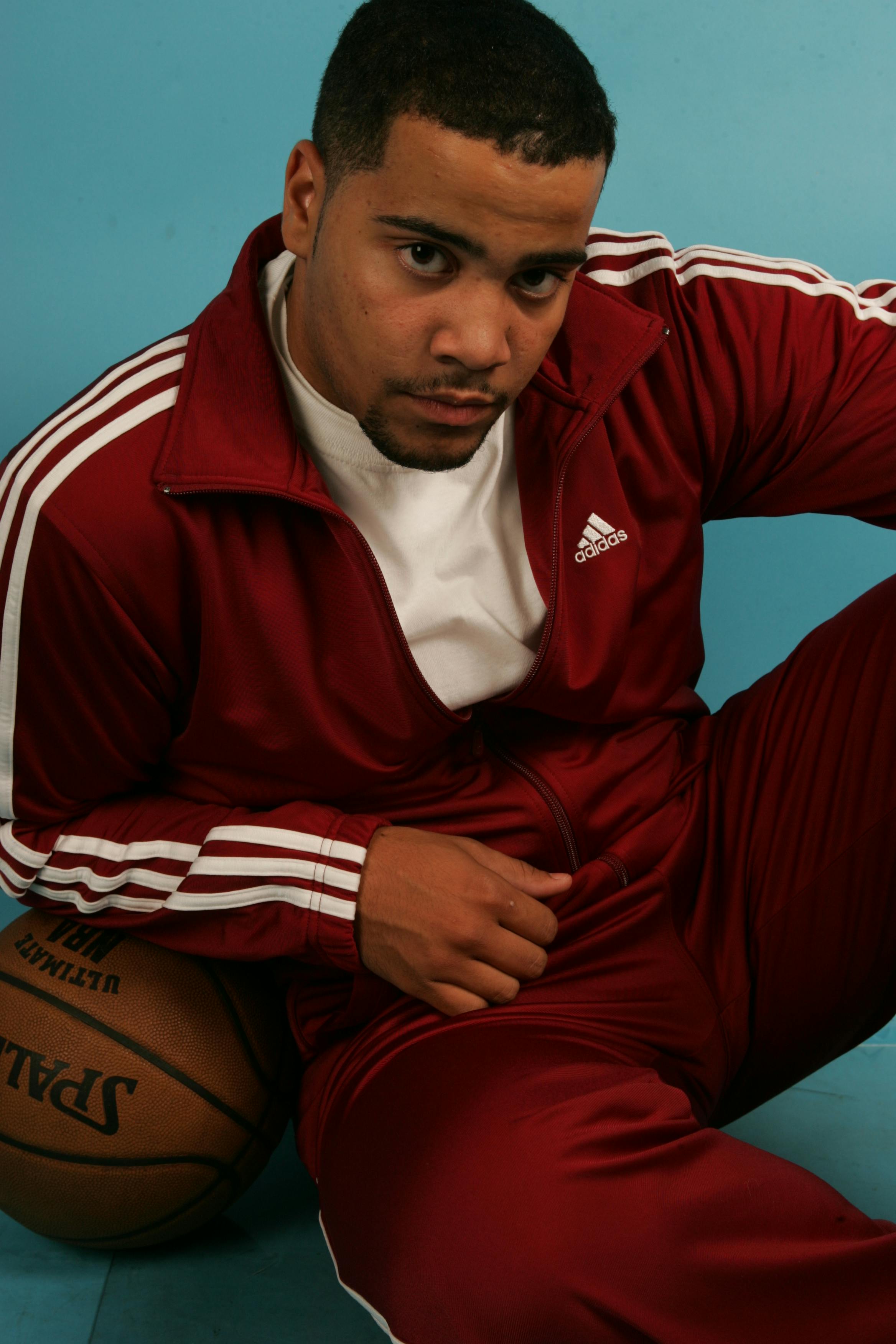 Man in a Tracksuit Sitting by a Basketball · Free Stock Photo