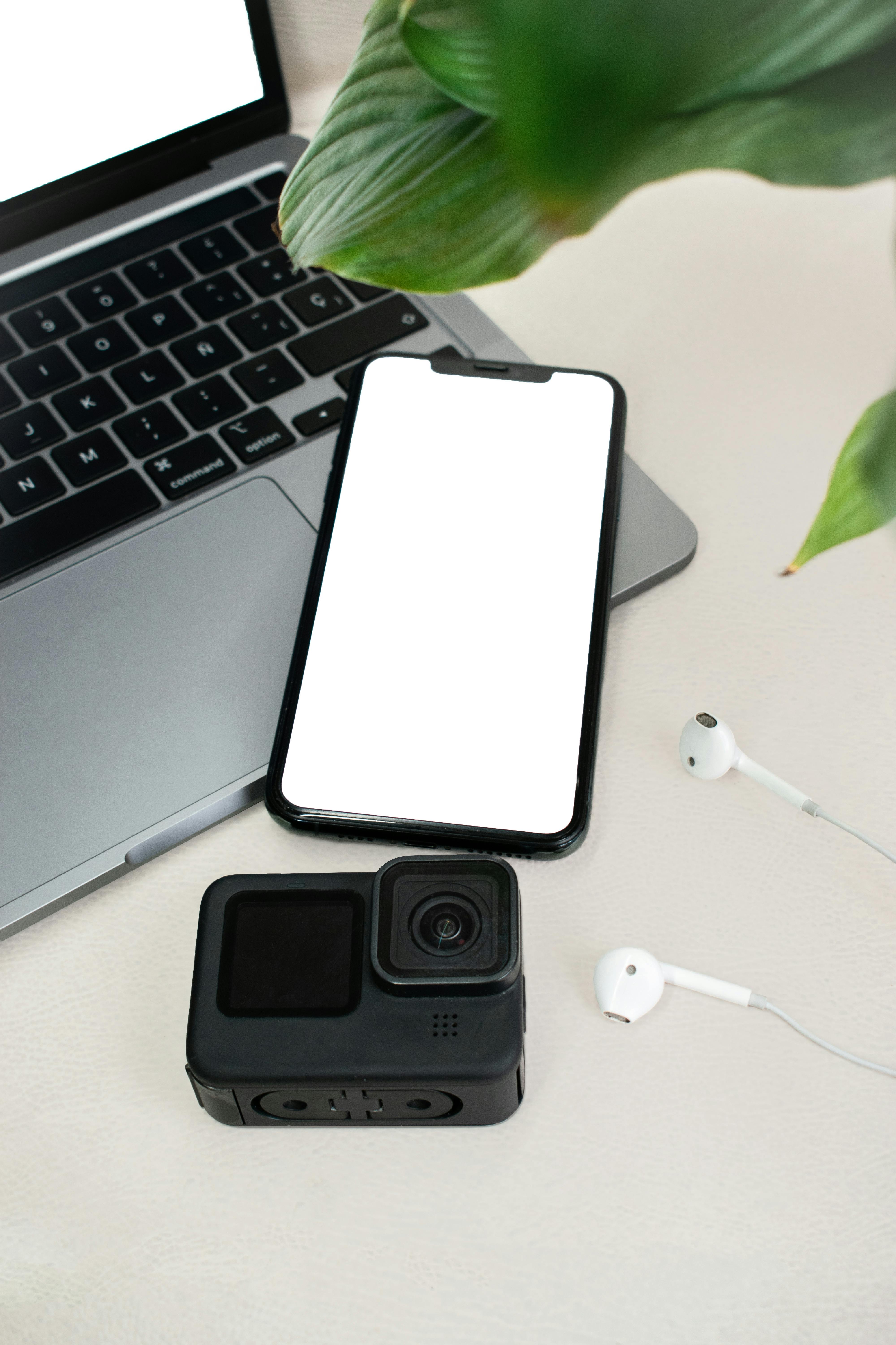 A Smartphone and Camera Near a Laptop · Free Stock Photo