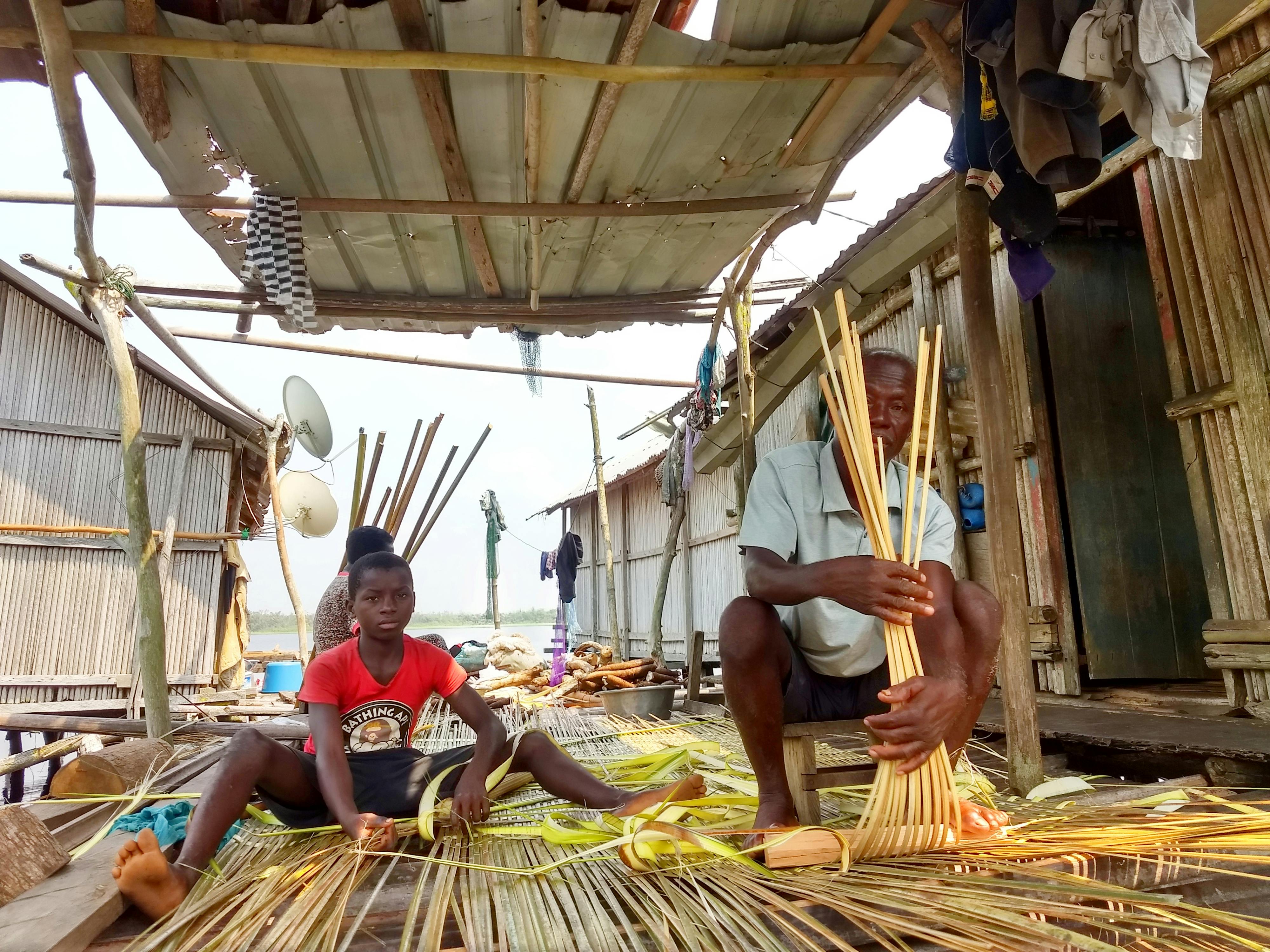 People Weaving Bamboo Outside Their Wooden House · Free Stock Photo