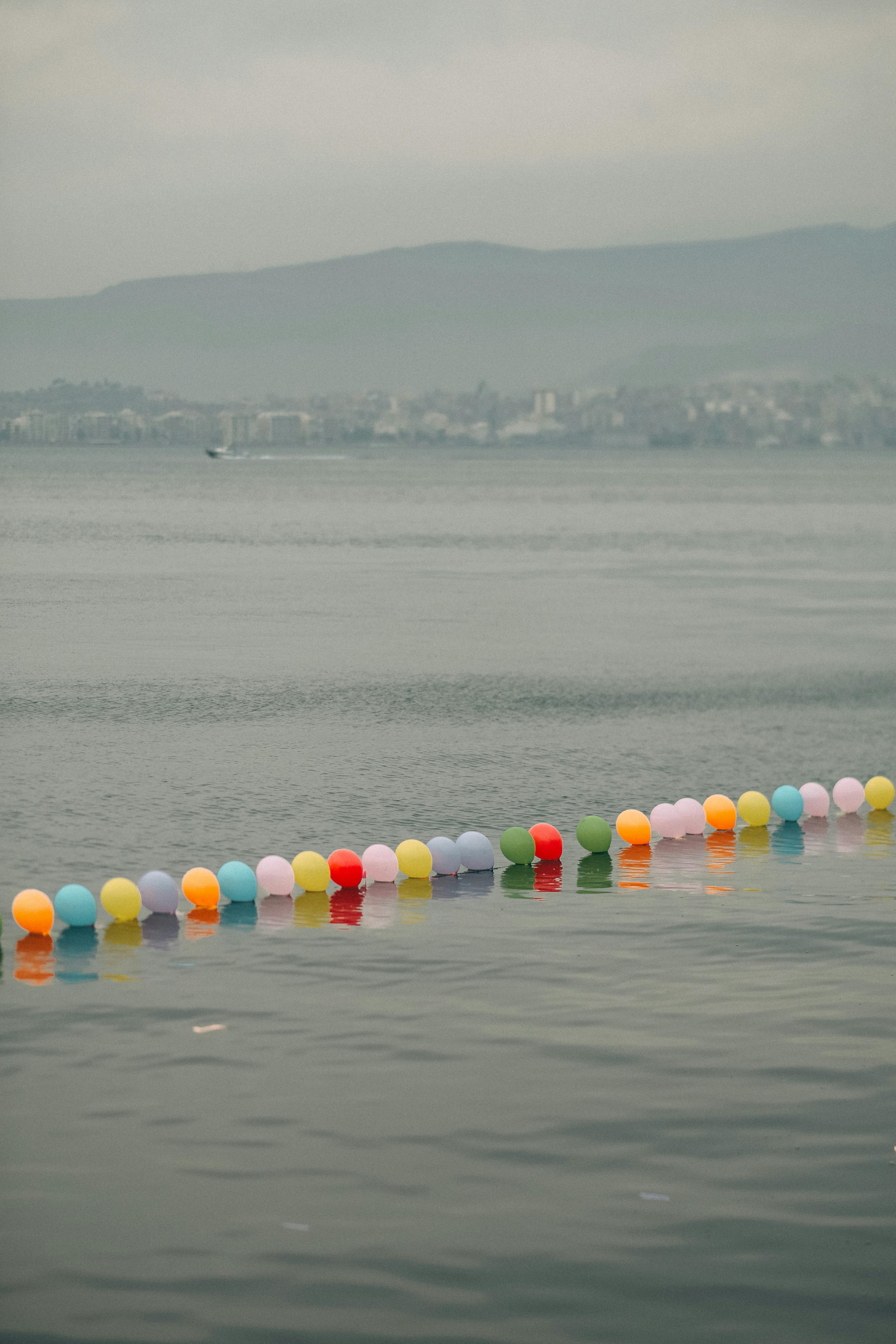 A Colorful Balloons on Body of Water · Free Stock Photo