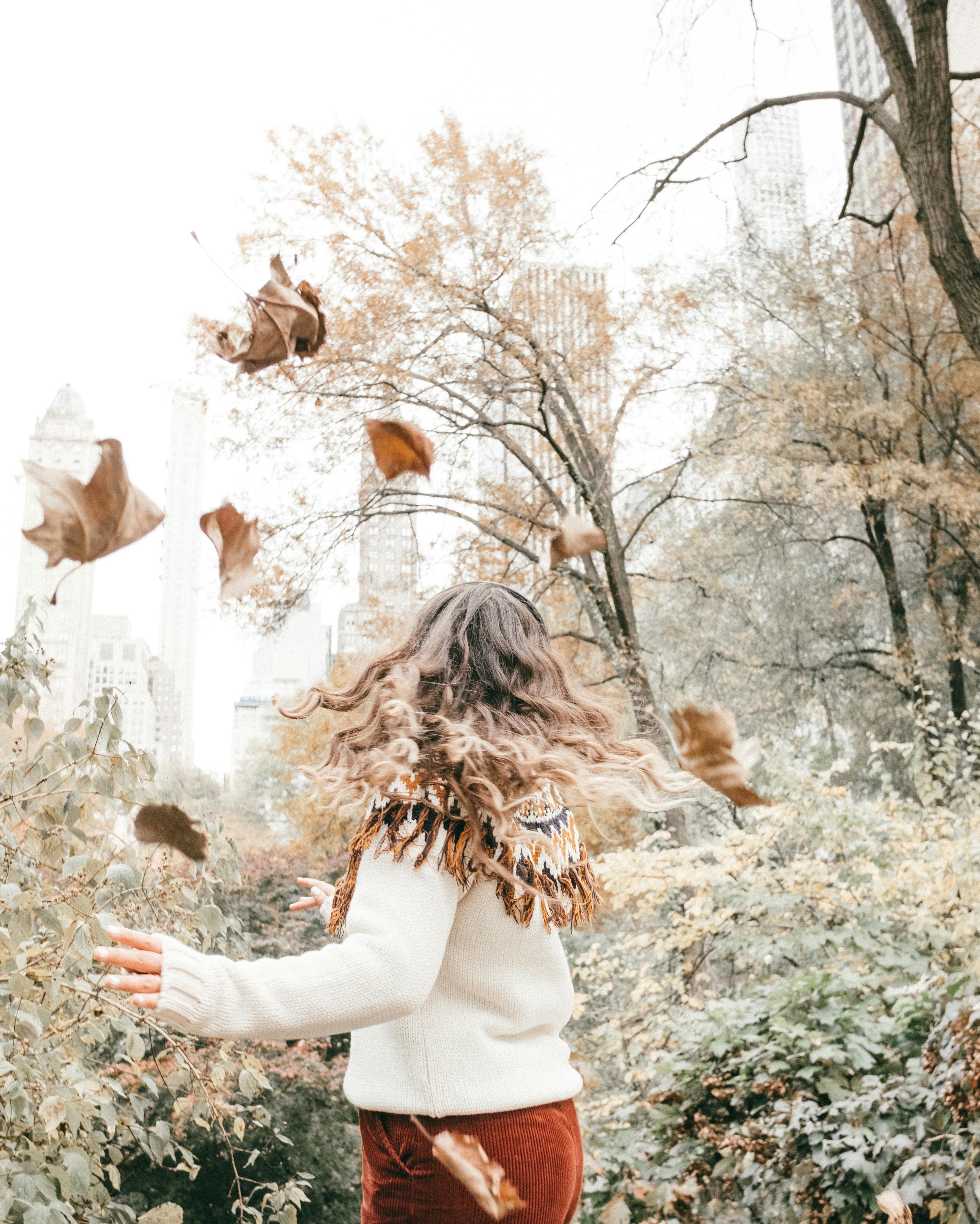 Woman Among Frozen Trees with Falling Autumn Leaves above Her · Free ...