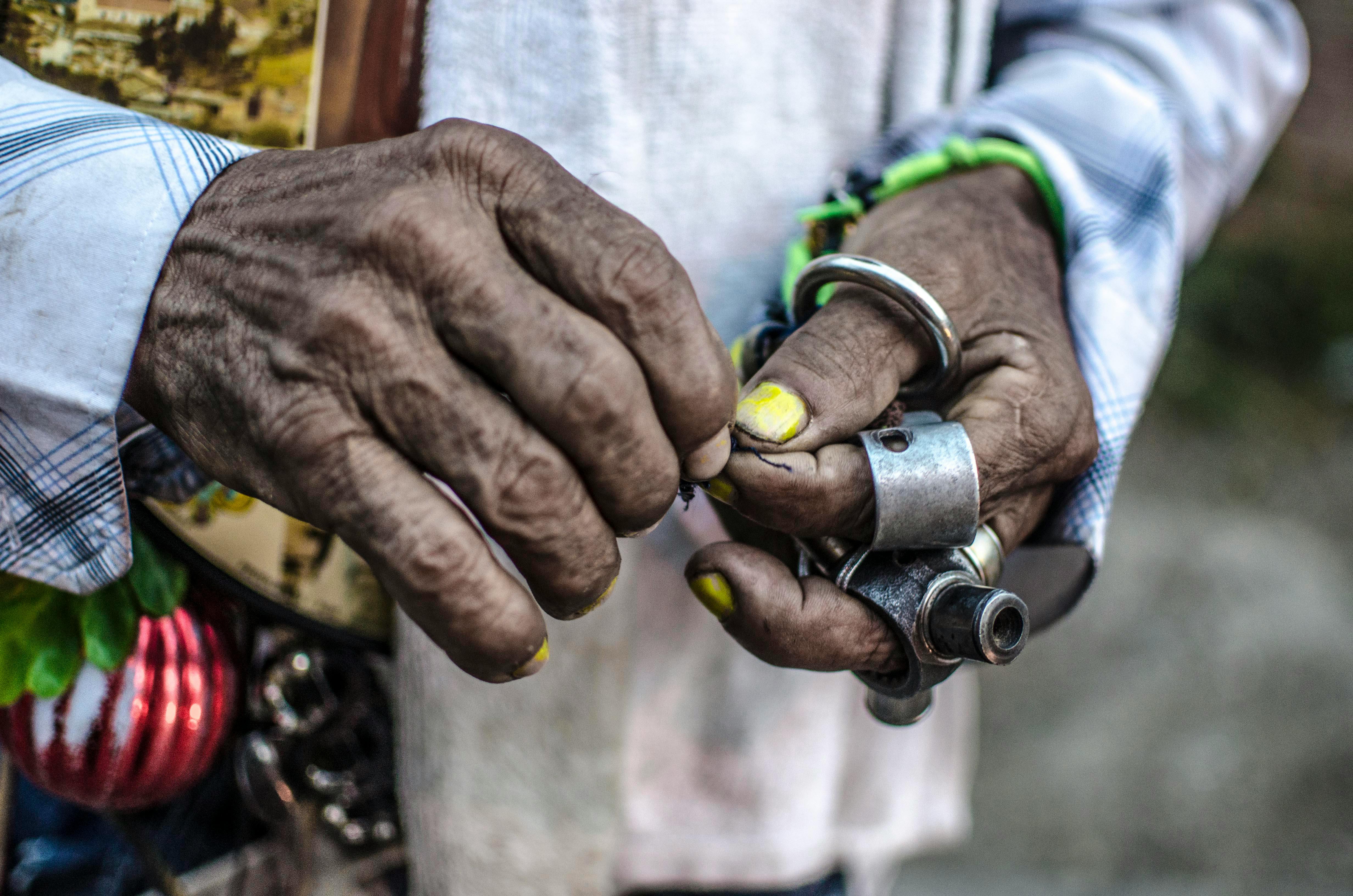 A Person Greasing a Part of a Metal Engine · Free Stock Photo