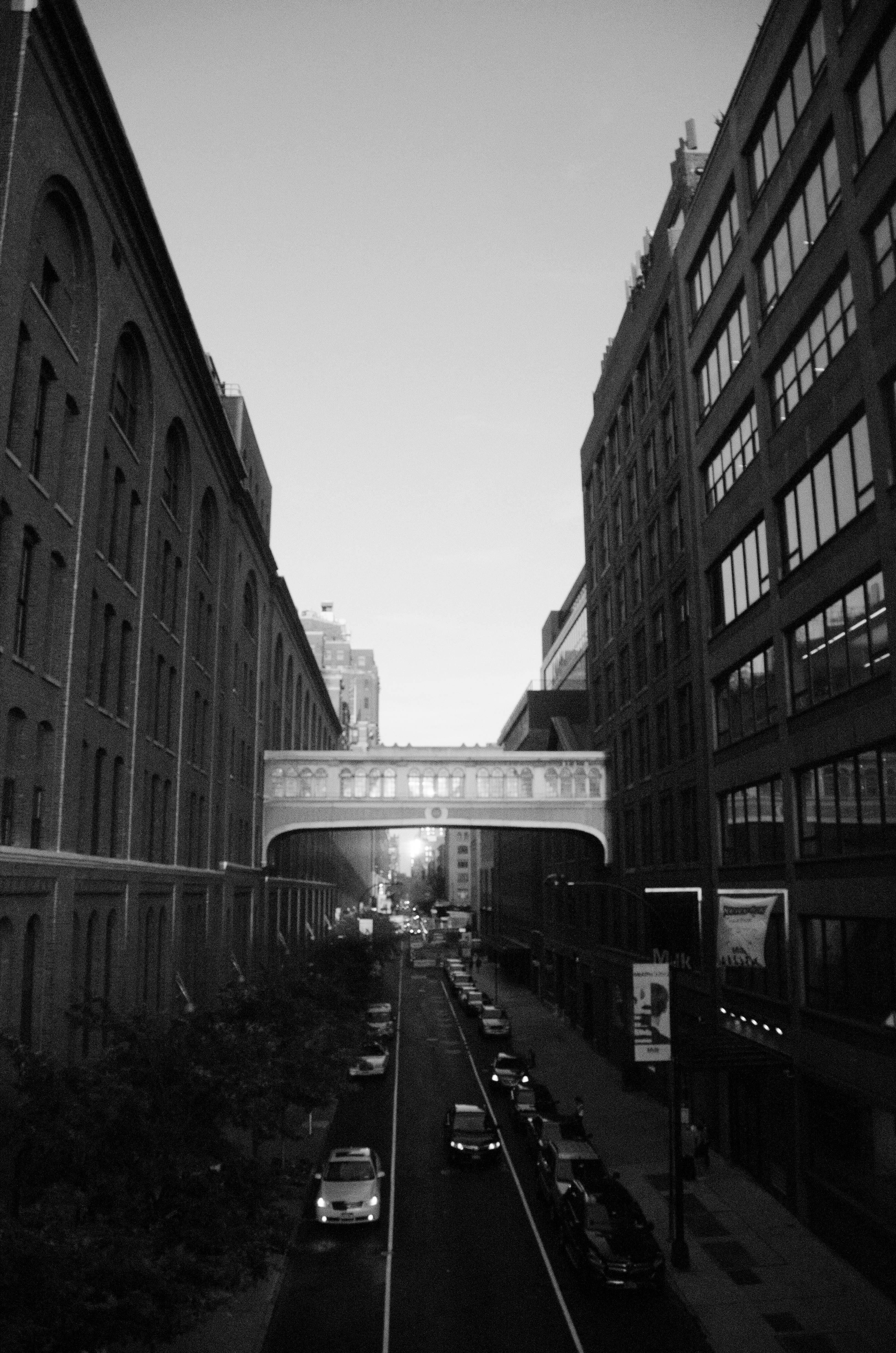 Grayscale Photo of Cars on the Road in between City Buildings · Free ...