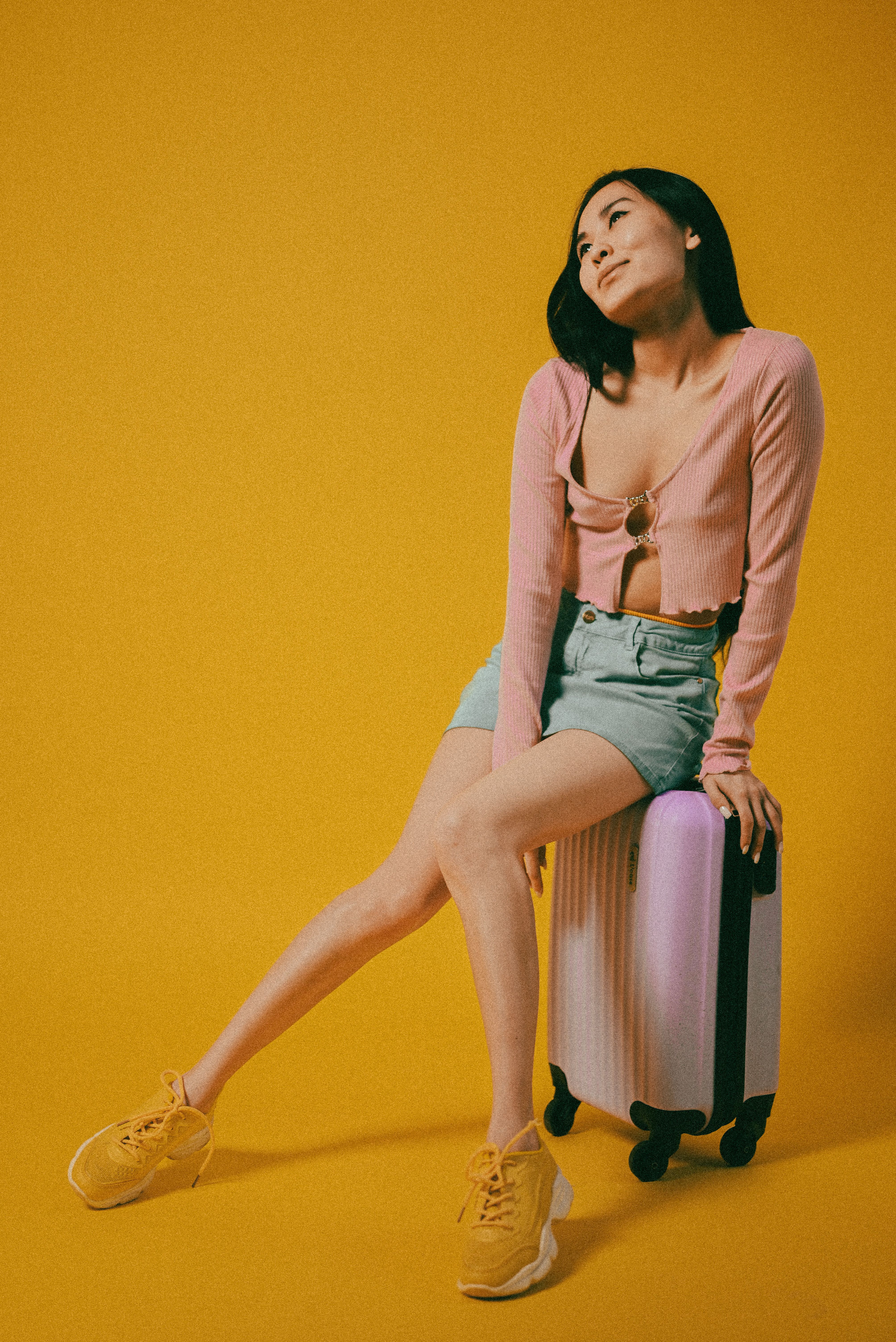 Woman in Pink Cardigan Sitting on White and Black Luggage · Free Stock ...