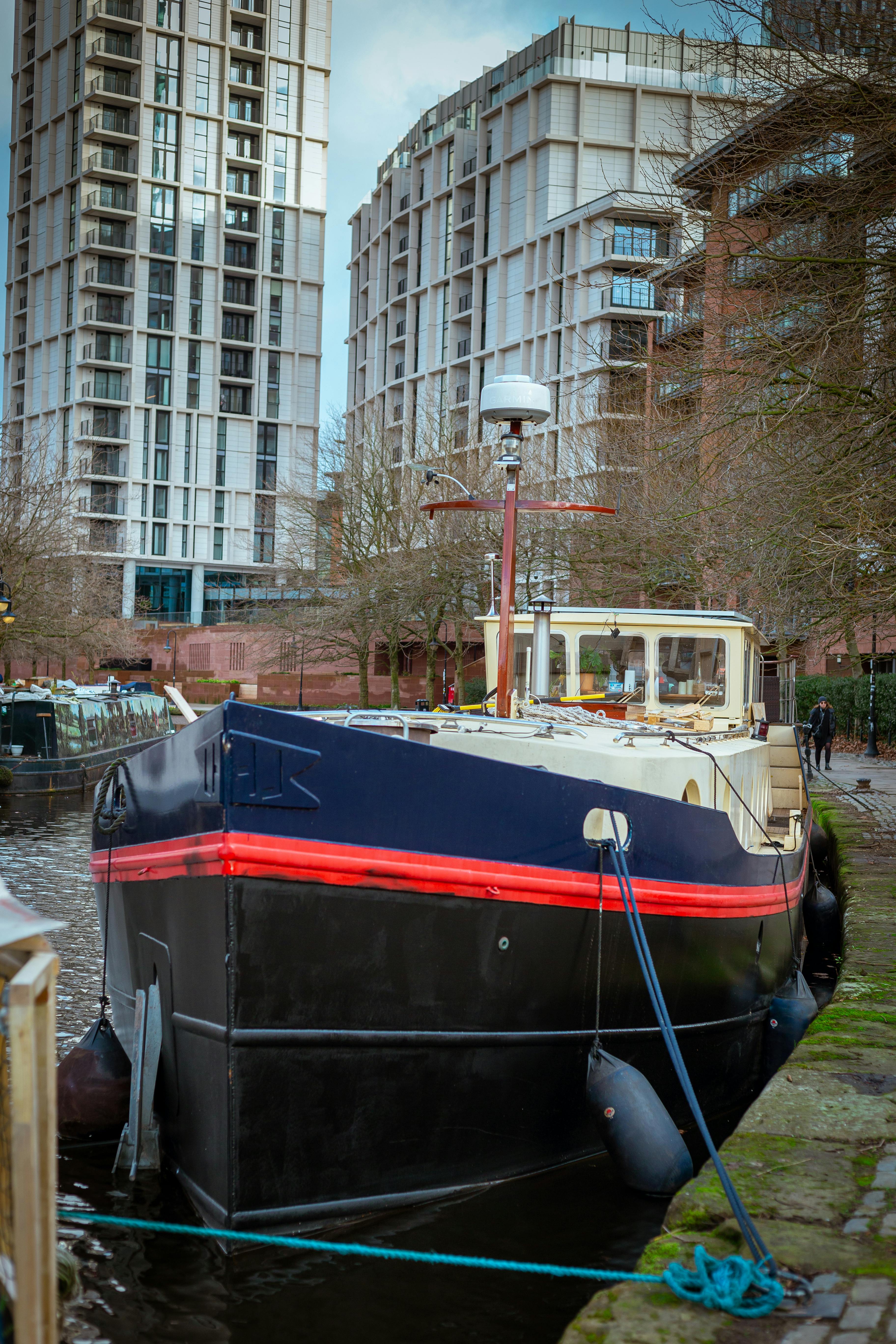 Recreational Boat on a City Canal and Modern Architecture in Background ...