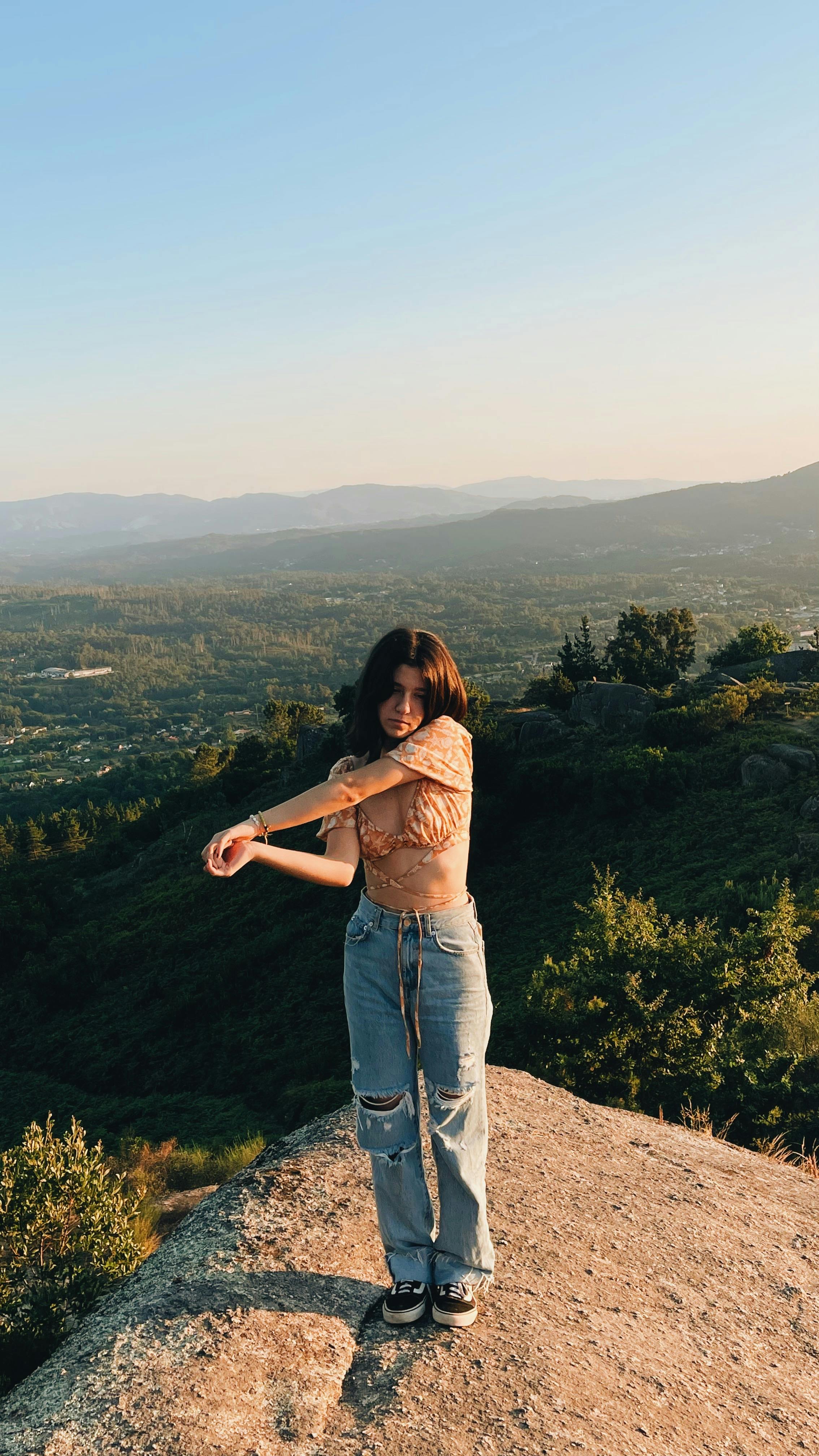 Girl Posing on a Rock and Mountain Landscape in Background · Free Stock ...