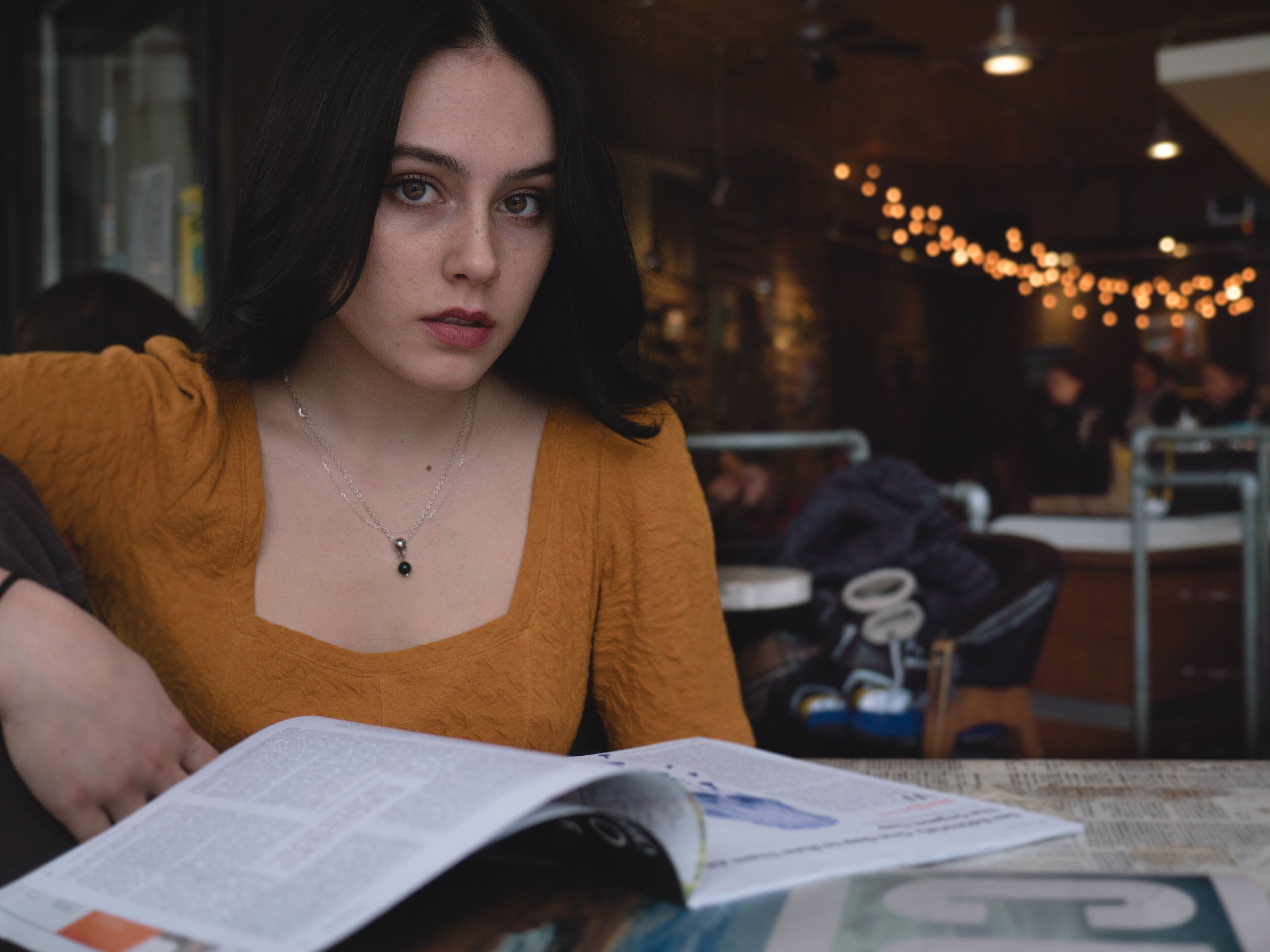 A Woman in Brown Cardigan Sitting on Chair · Free Stock Photo