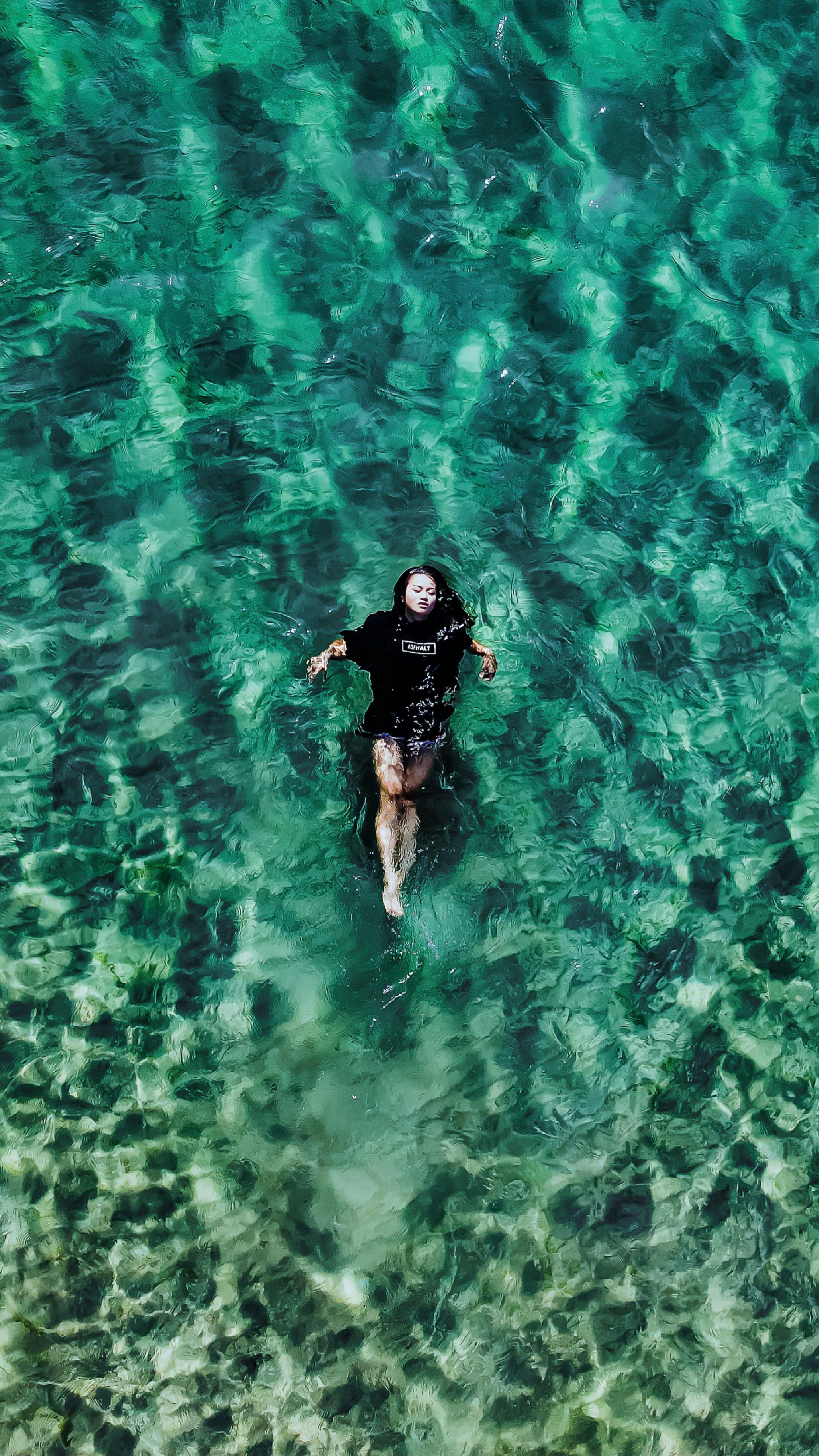 Person Swimming and Floating on Sea Wearing Black shirt · Free Stock Photo