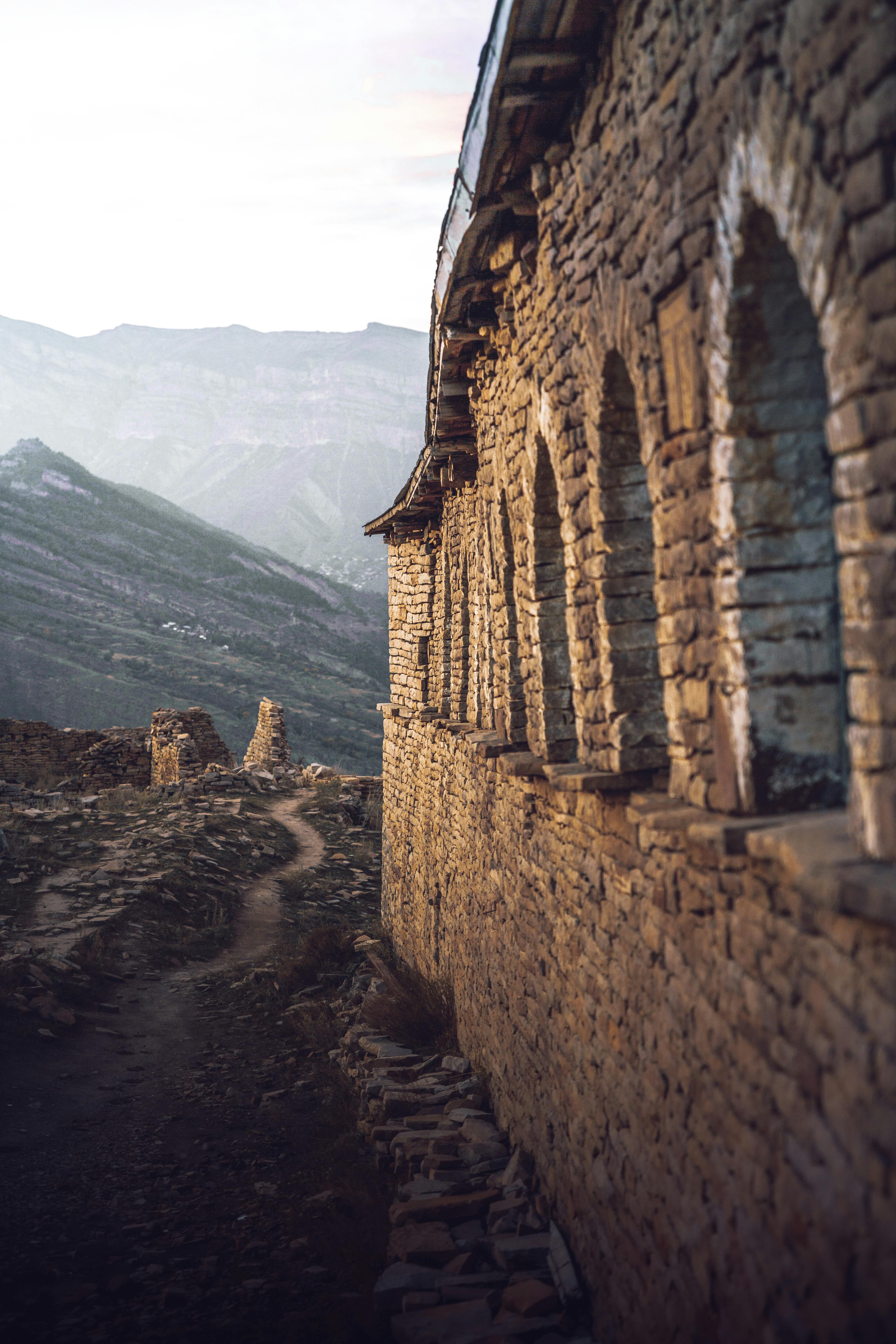 Historic Brick Building Facade and a Mountain Range · Free Stock Photo