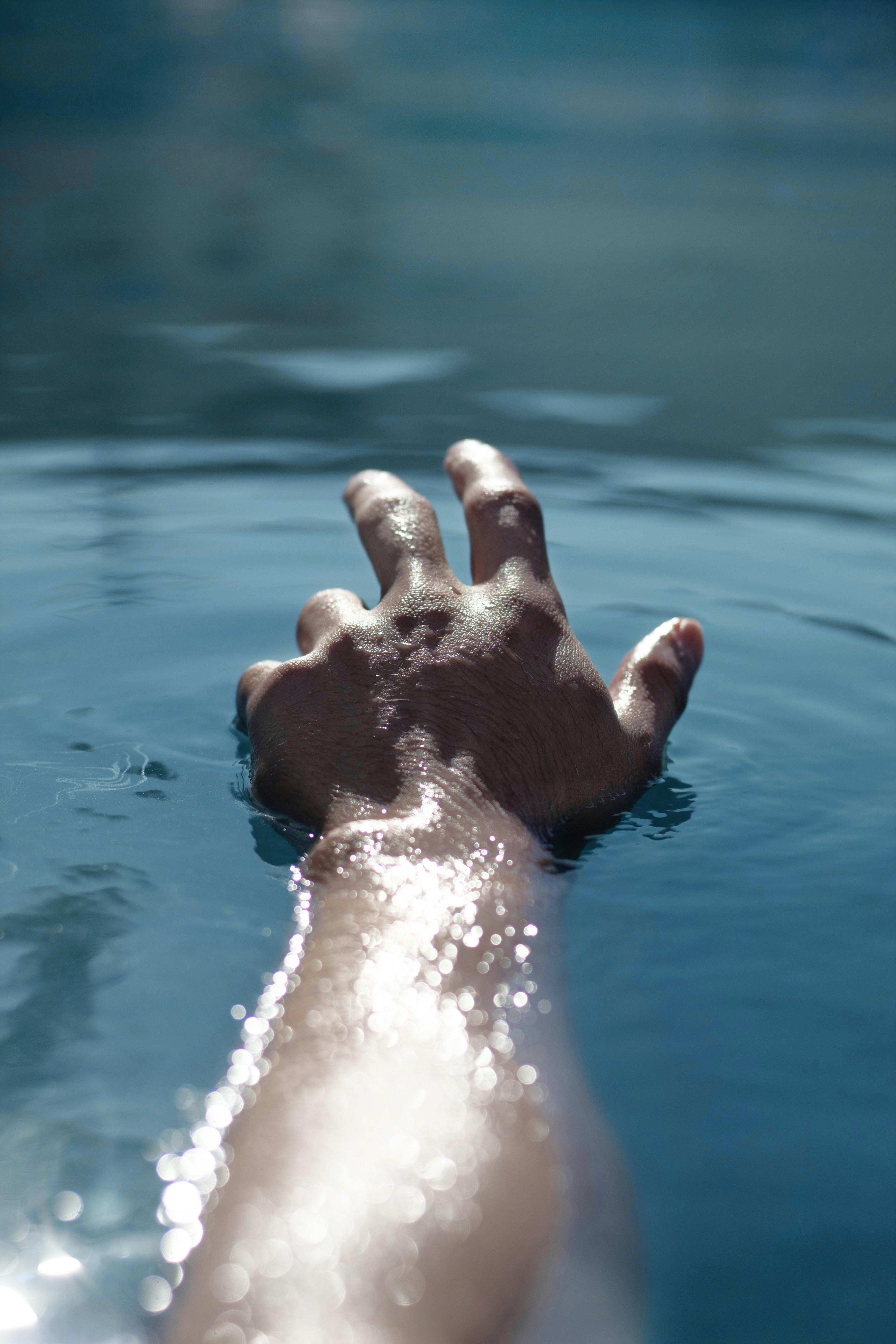 Crop man with hands under transparent water · Free Stock Photo