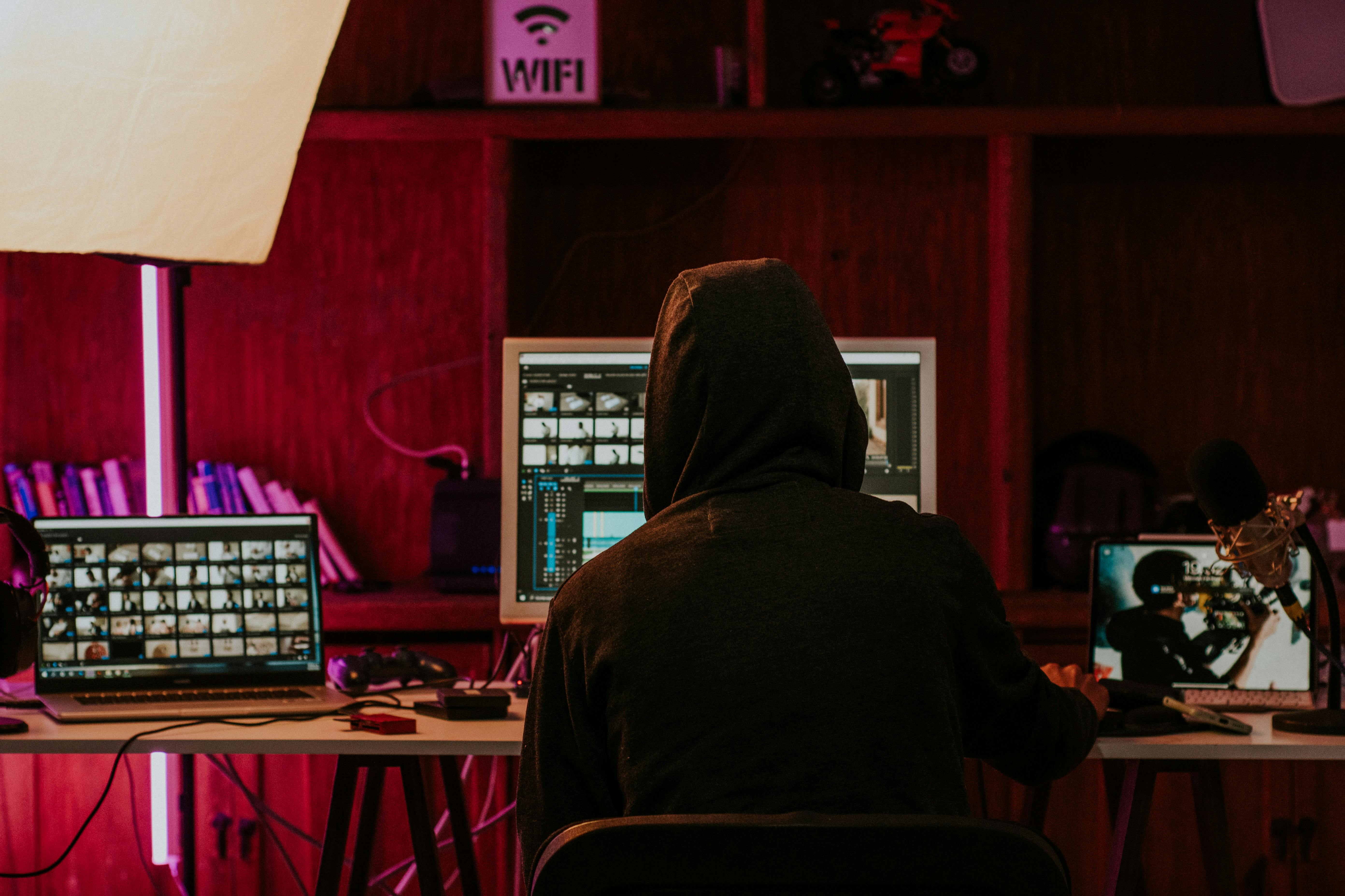 Man Wearing Hoodie and Using Computers · Free Stock Photo