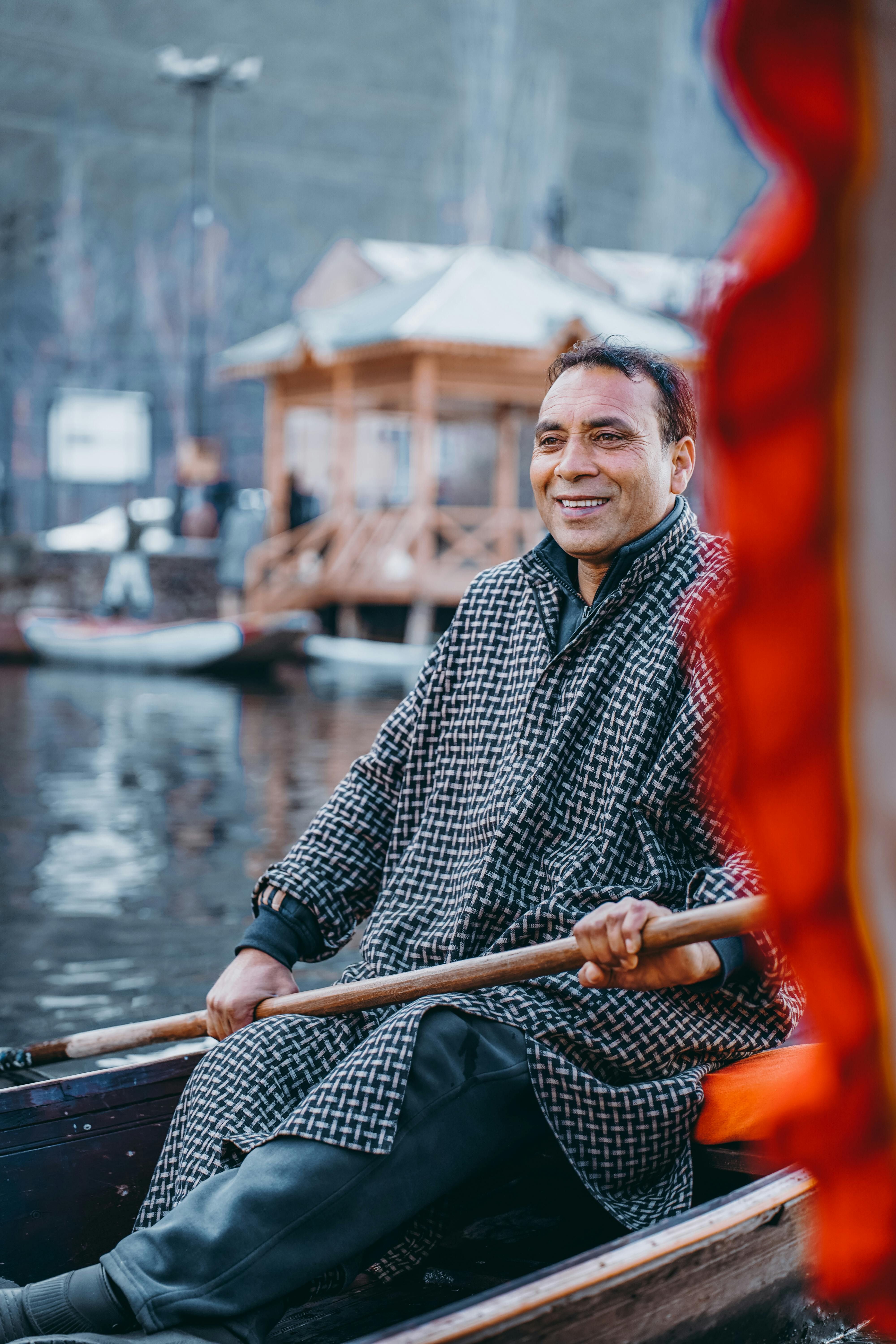Man in Checkered Coat Rowing a Boat · Free Stock Photo