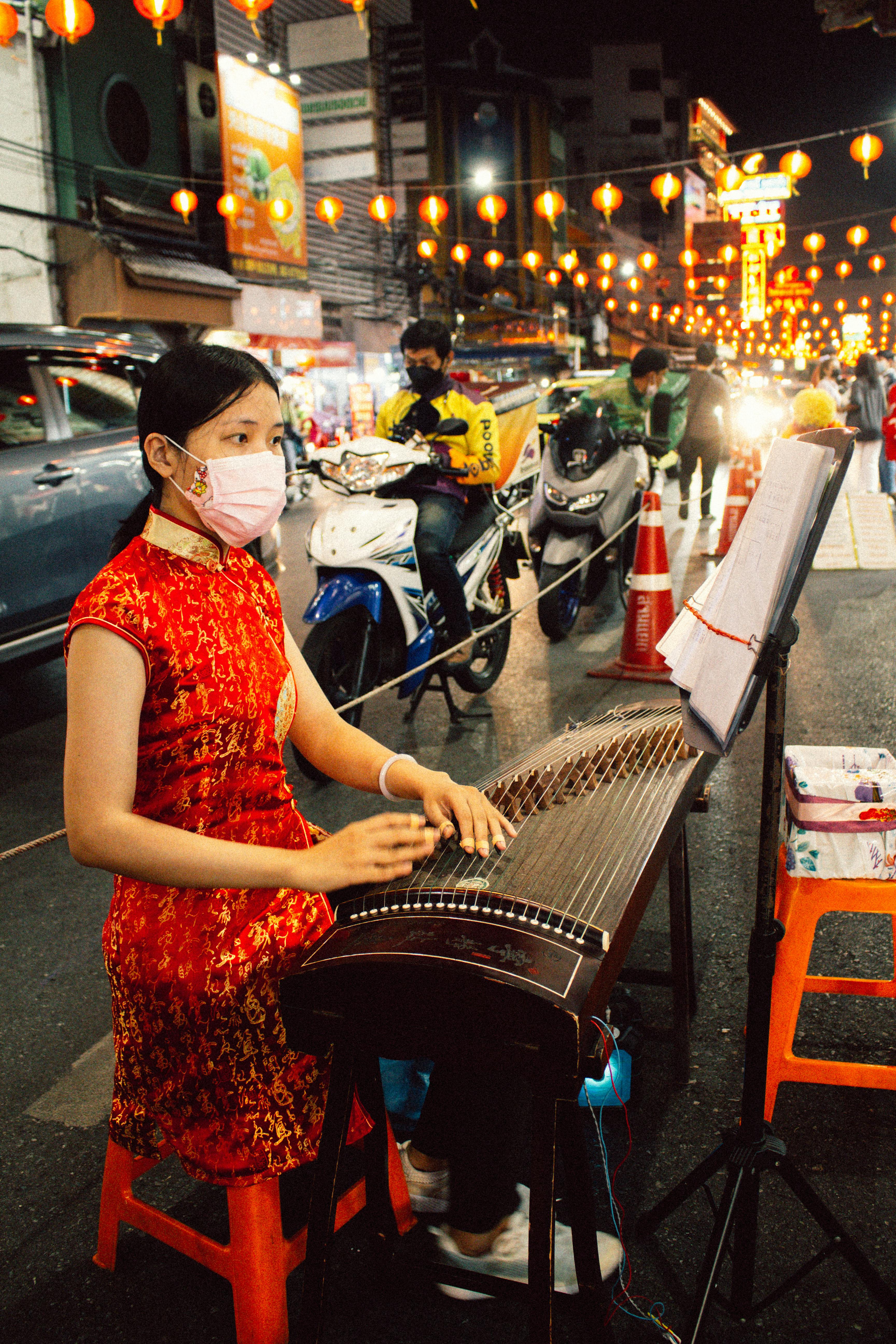 A Woman in Red Traditional Clothing Playing Stringed Instrument on the ...
