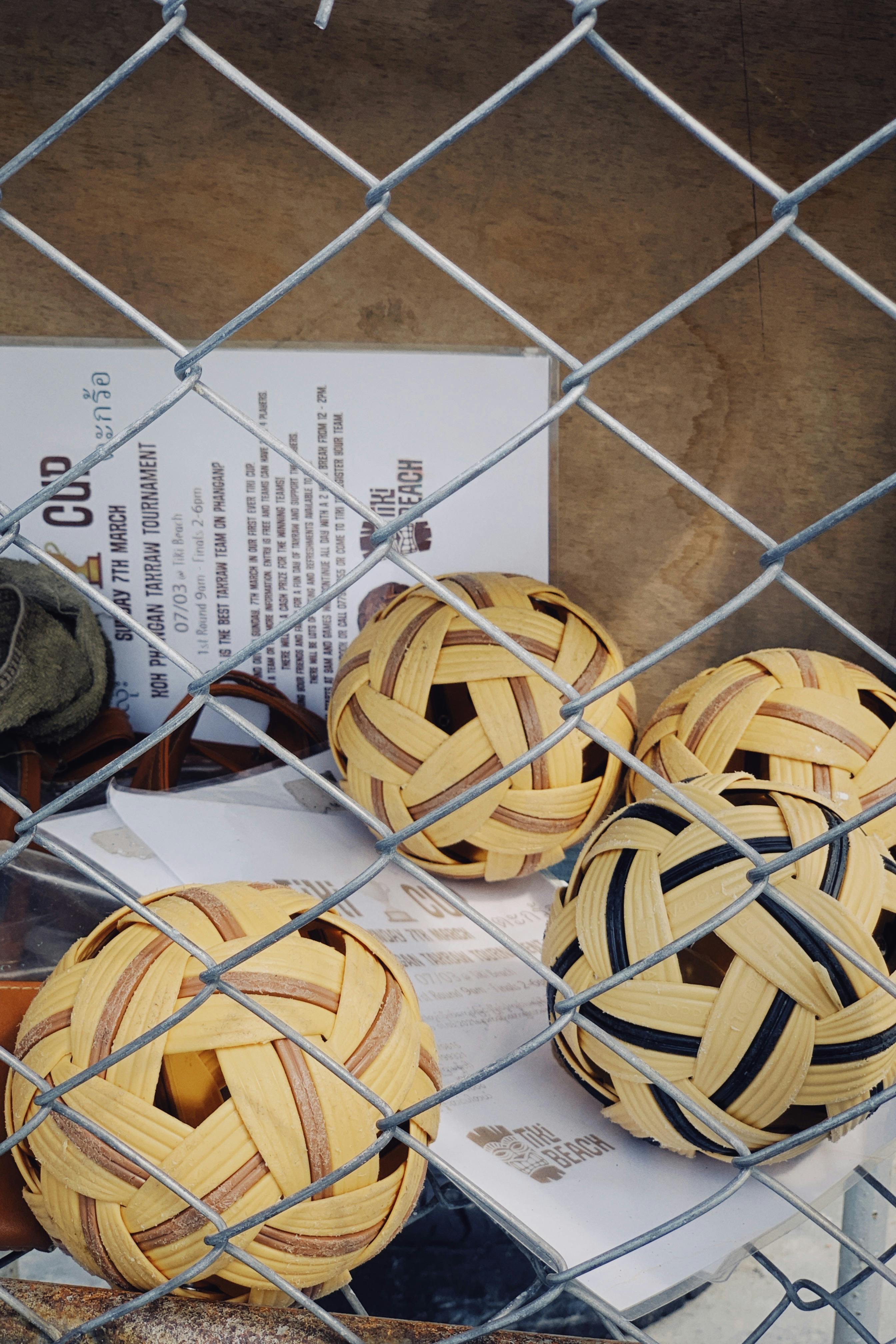 Sepak Takraw Balls Behind Chain Link Fence · Free Stock Photo
