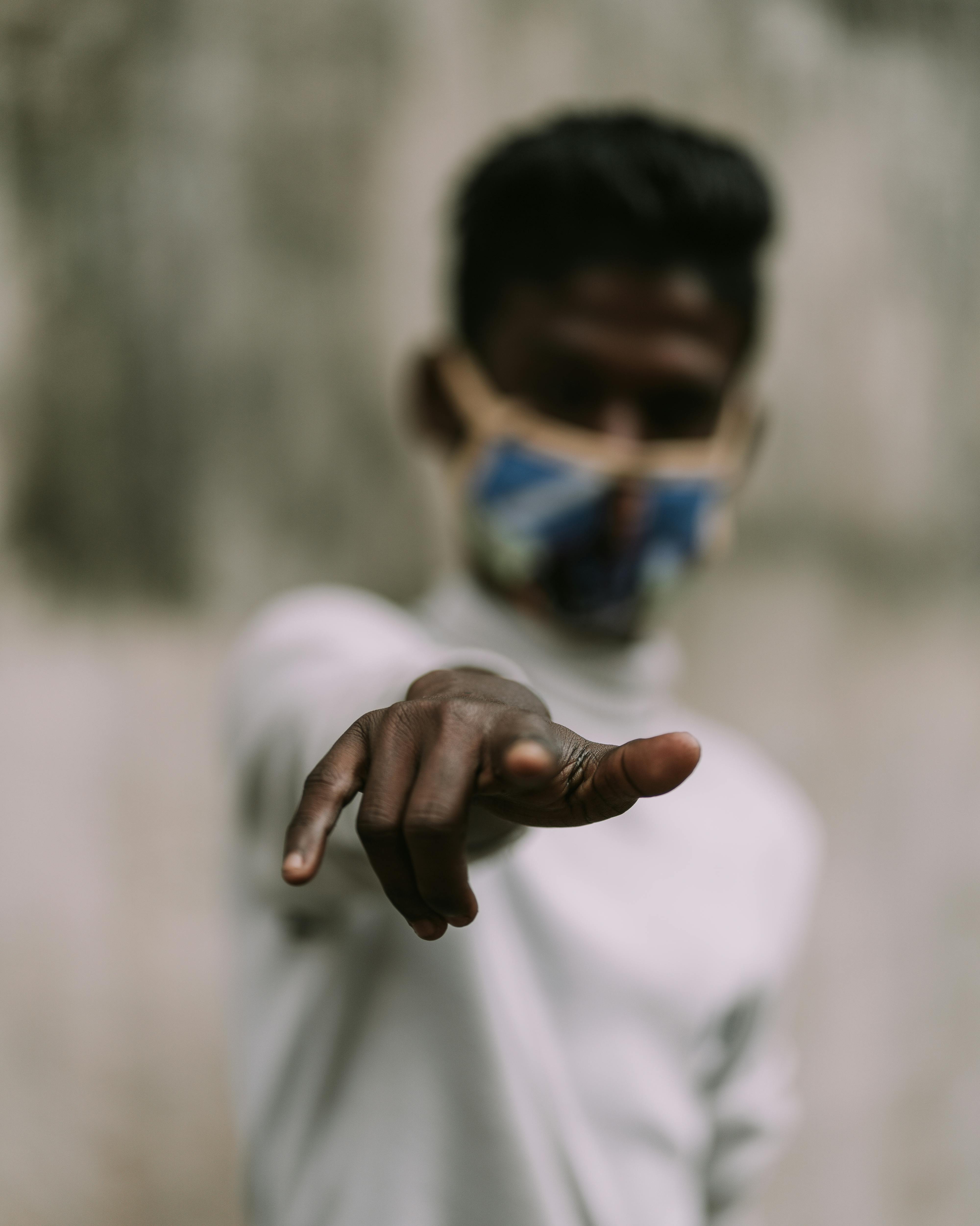 Man in Face Mask Pointing at Screen · Free Stock Photo