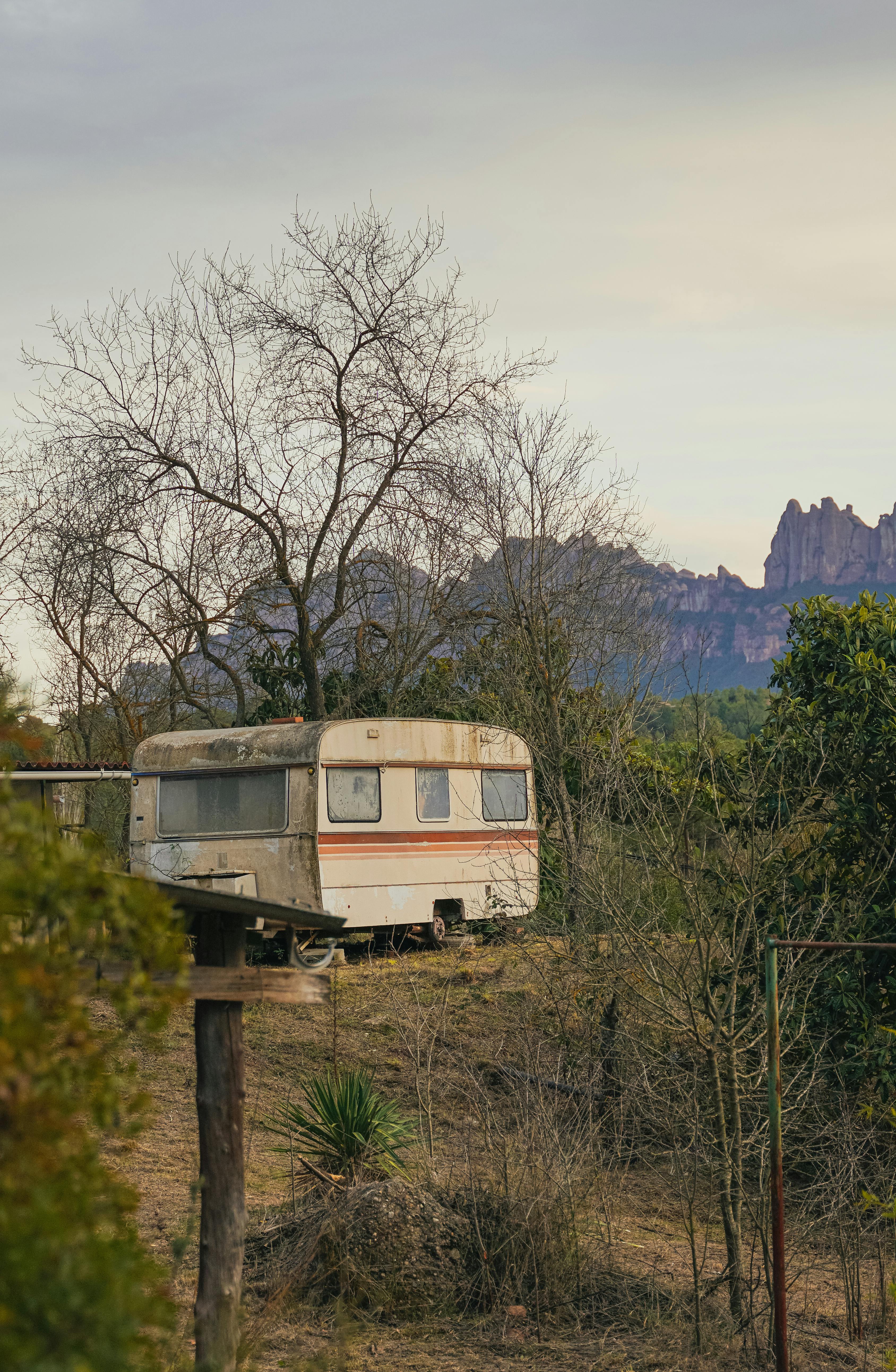 An Abandoned Campervan Near the Leafless Trees · Free Stock Photo