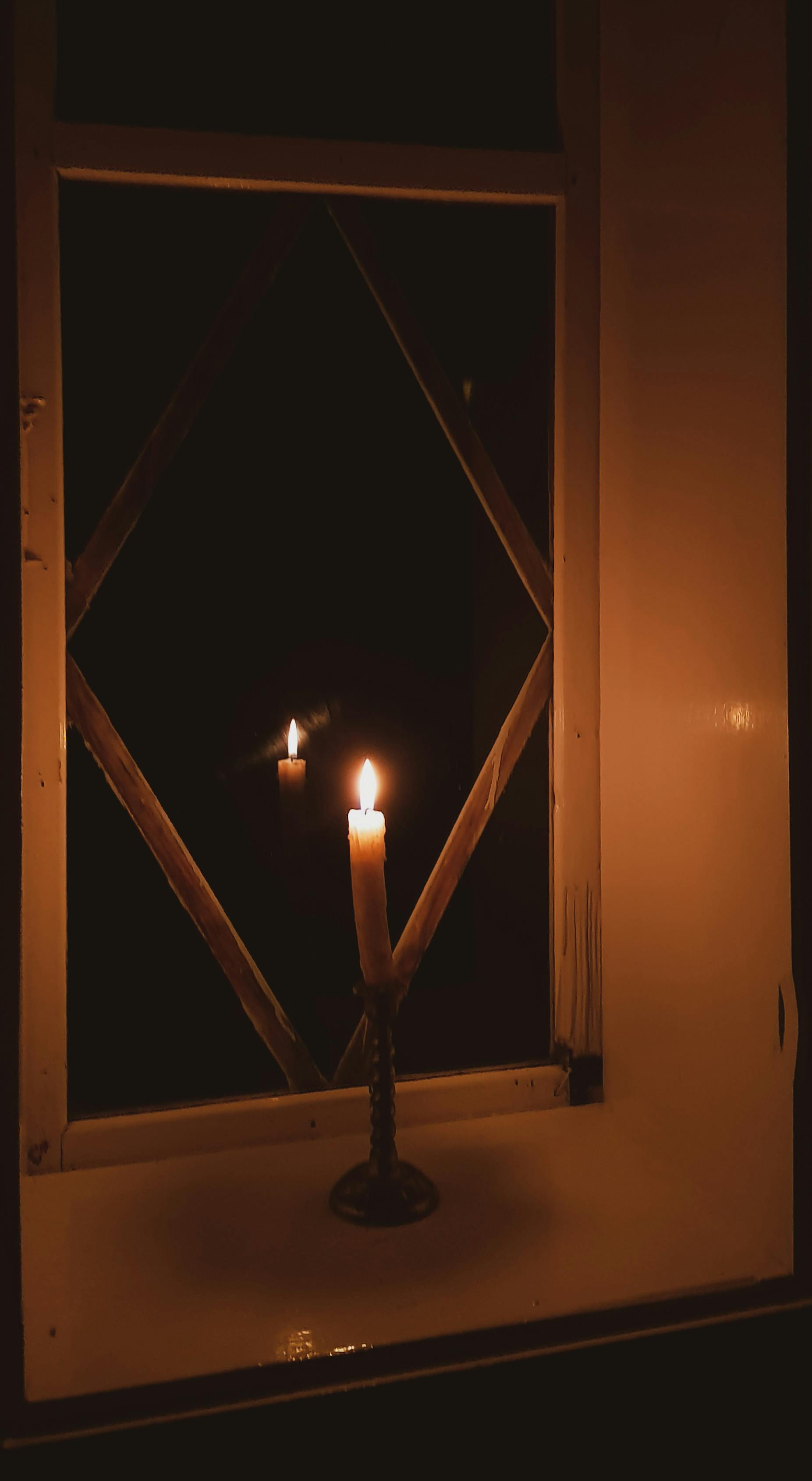 Lighted Candle Near a Glass Window · Free Stock Photo