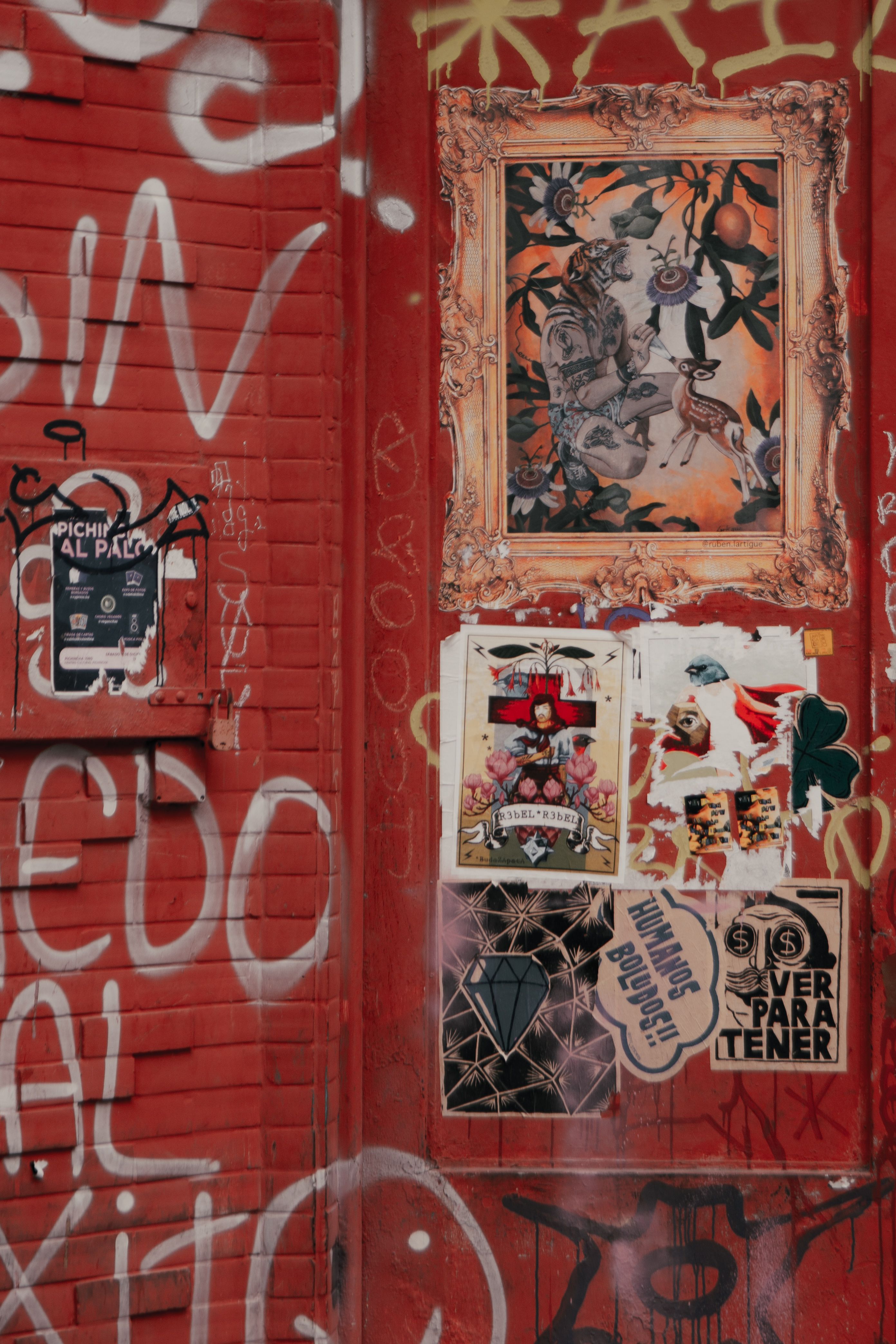 Photo of a Red Wall with Graffiti and Stickers · Free Stock Photo