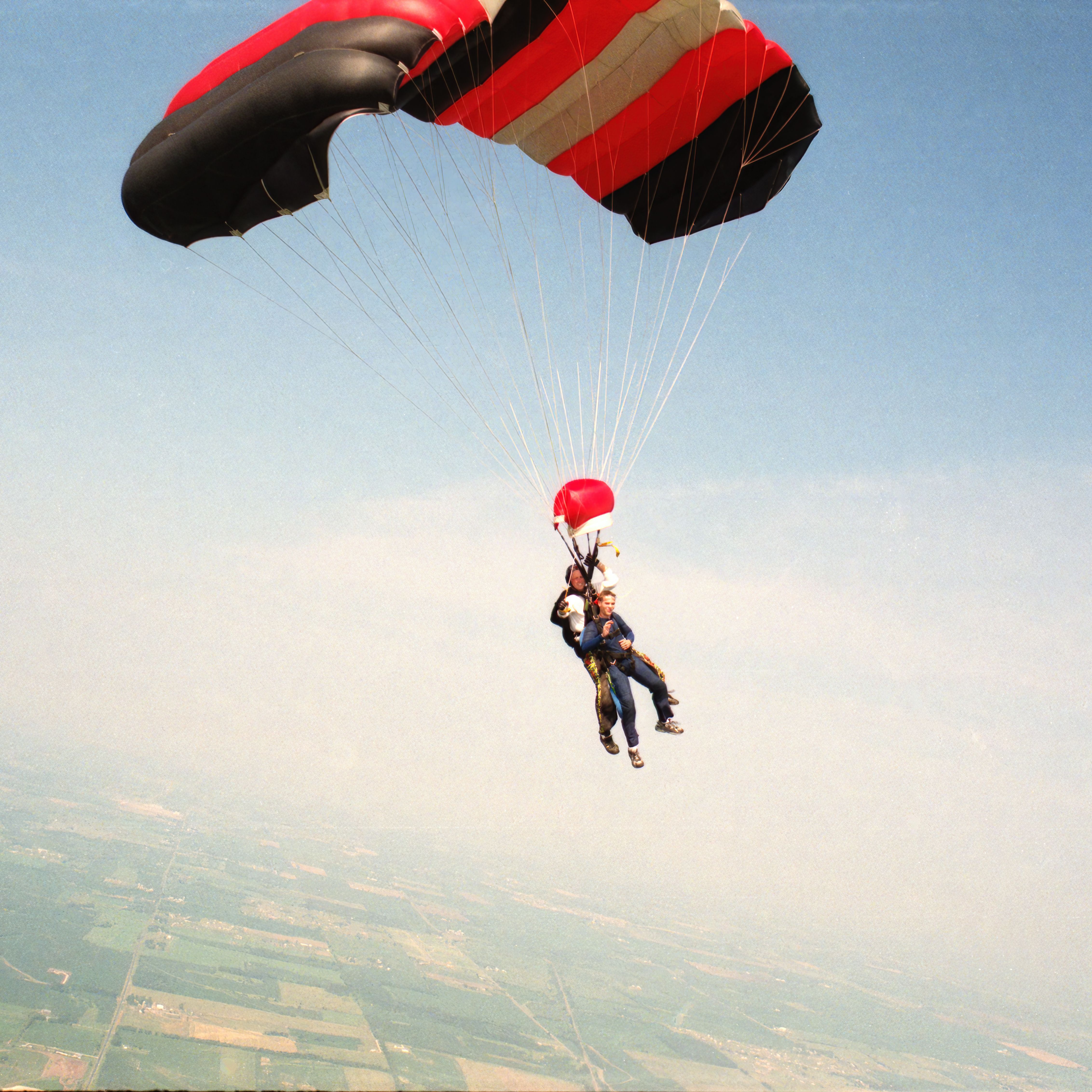 Aerial View of Two People Paragliding High Above Countryside Fields ...