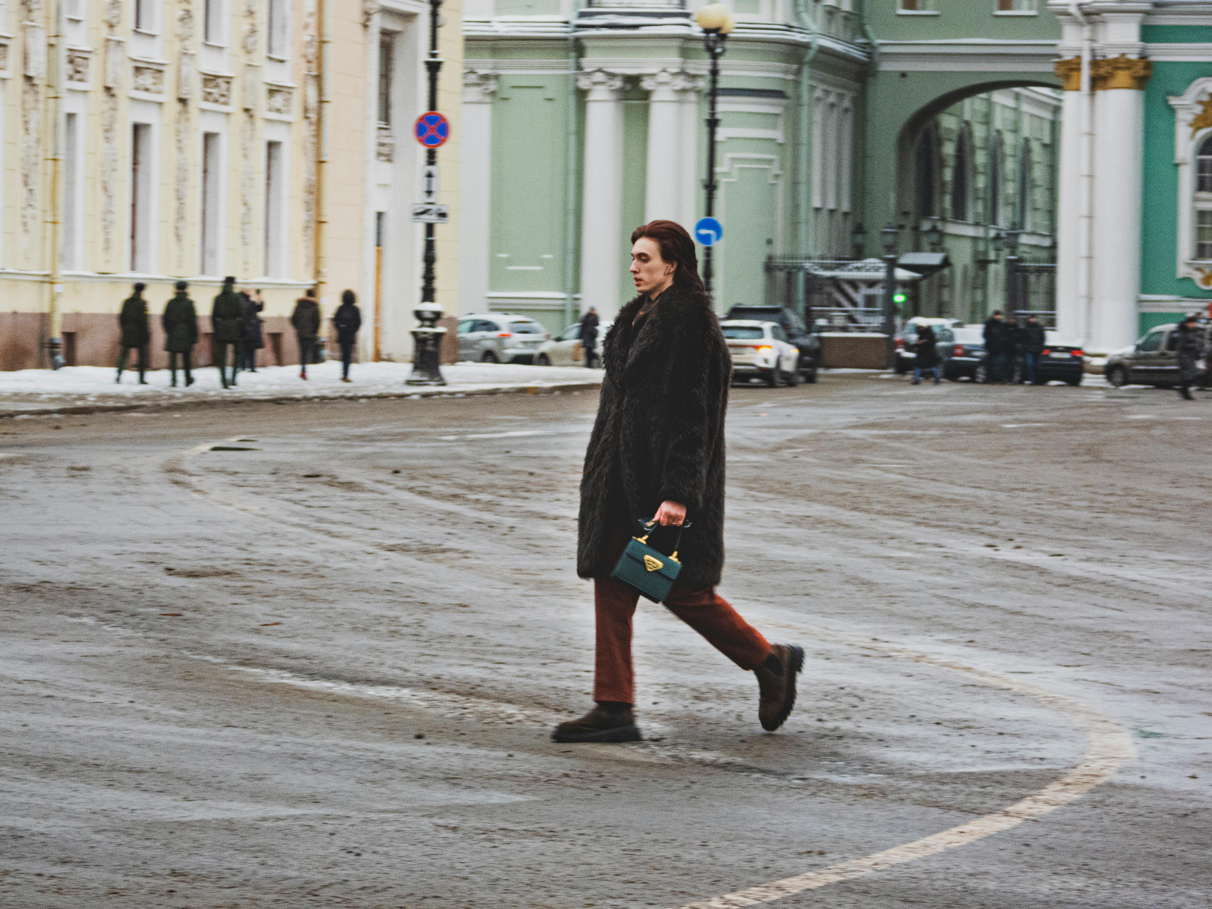 Male Fashion Model Wearing a Fur Coat Walking Across a Muddy Street in ...
