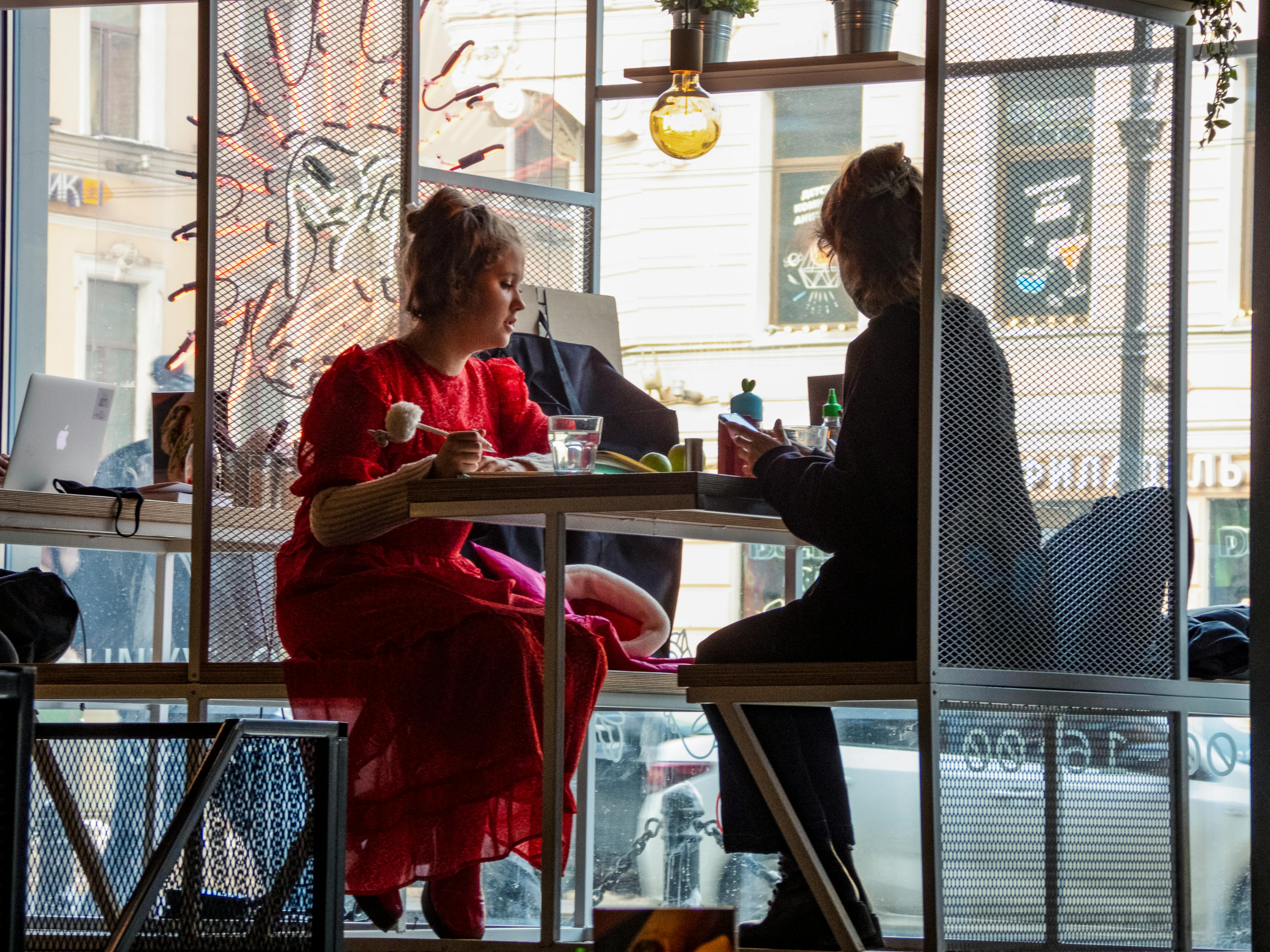 Two Women Sitting Together at a Cafe Table · Free Stock Photo