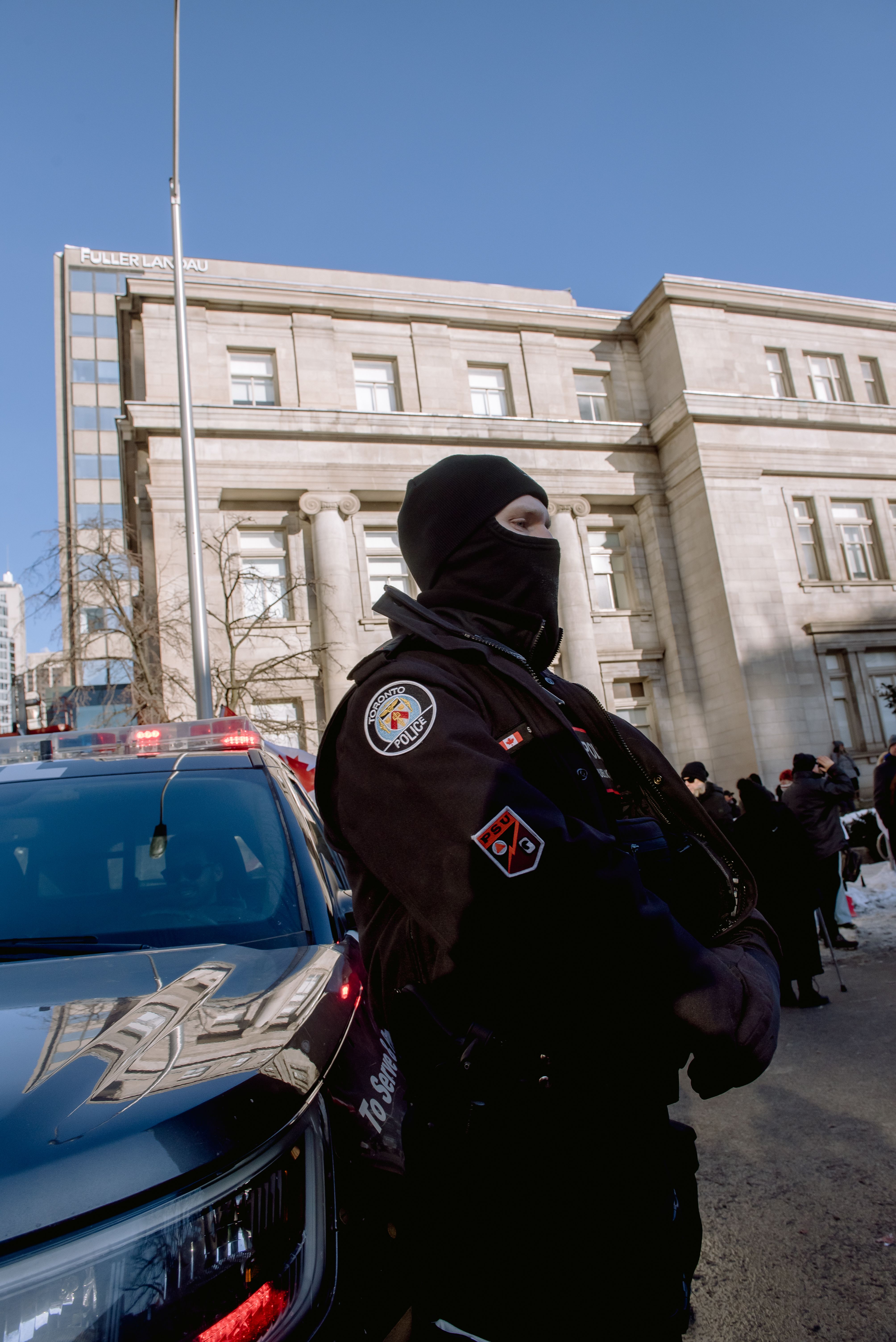 Two Police Men Standing Near Another Person Beside White and Blue ...