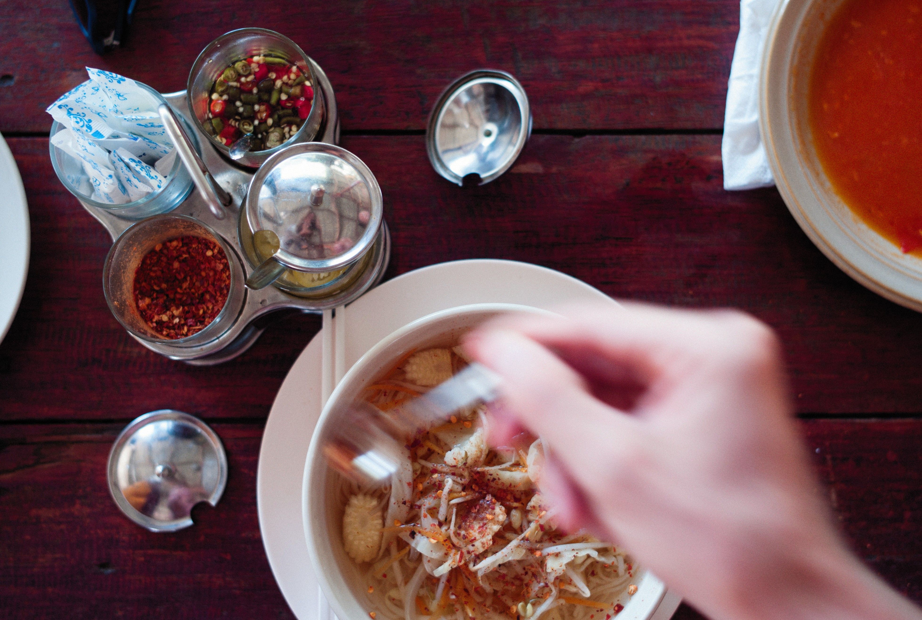 Overhead Shot of Condiments beside a Bowl of Soup · Free Stock Photo