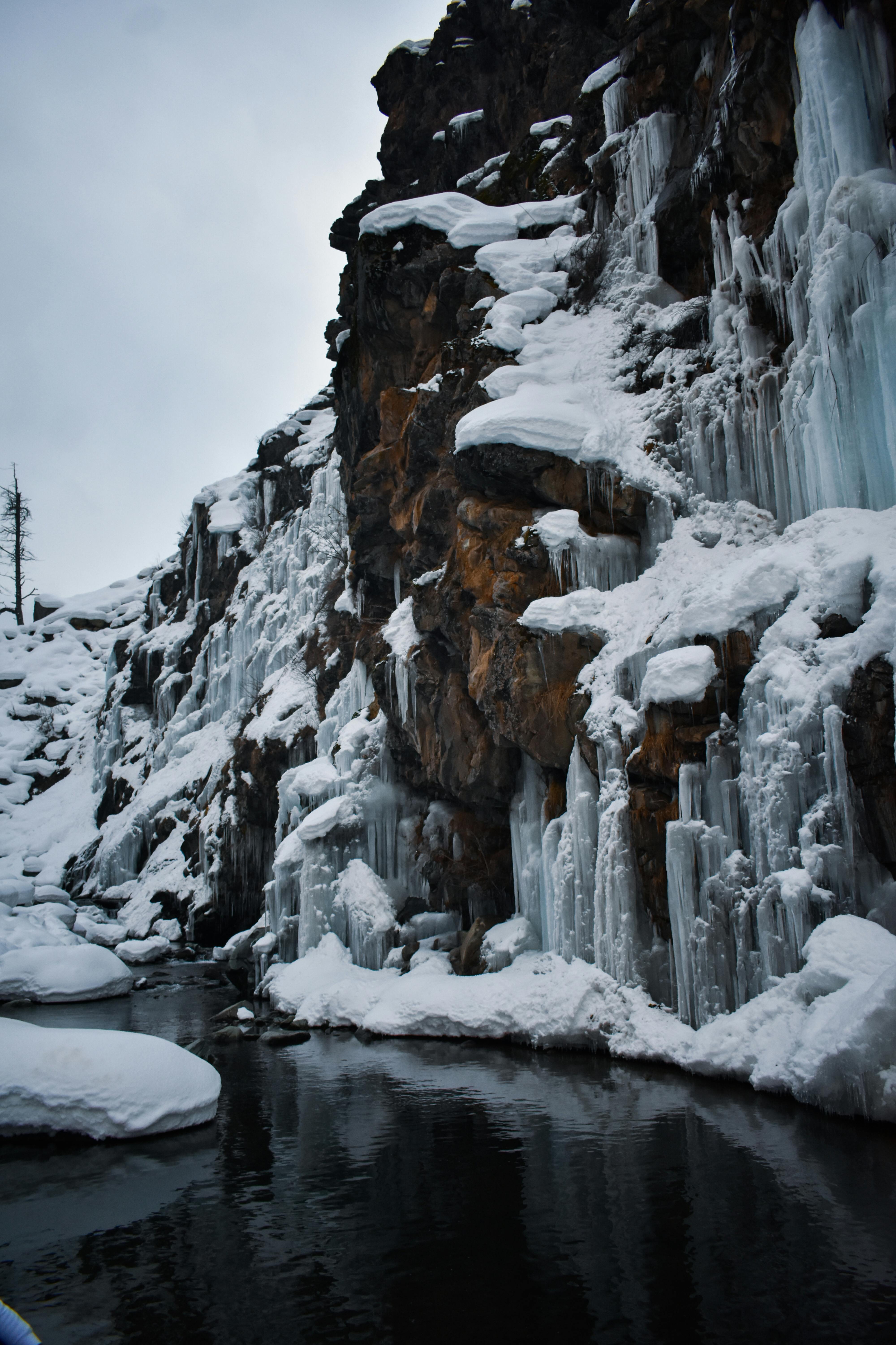 Snow Covered Mountain Rocks Near the River · Free Stock Photo